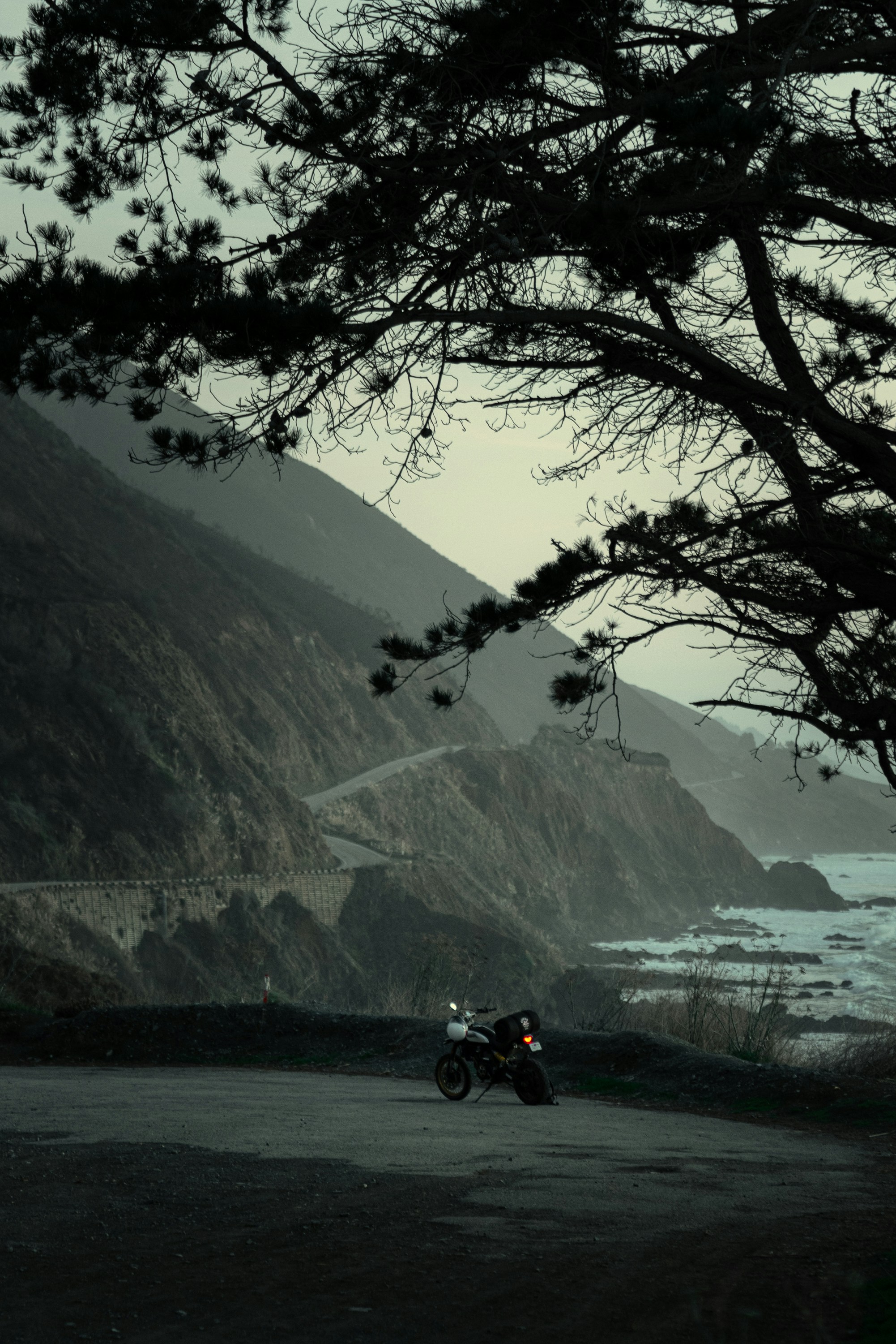 Silhouettes and Steel: A Motorcycle by the Cliffside Road