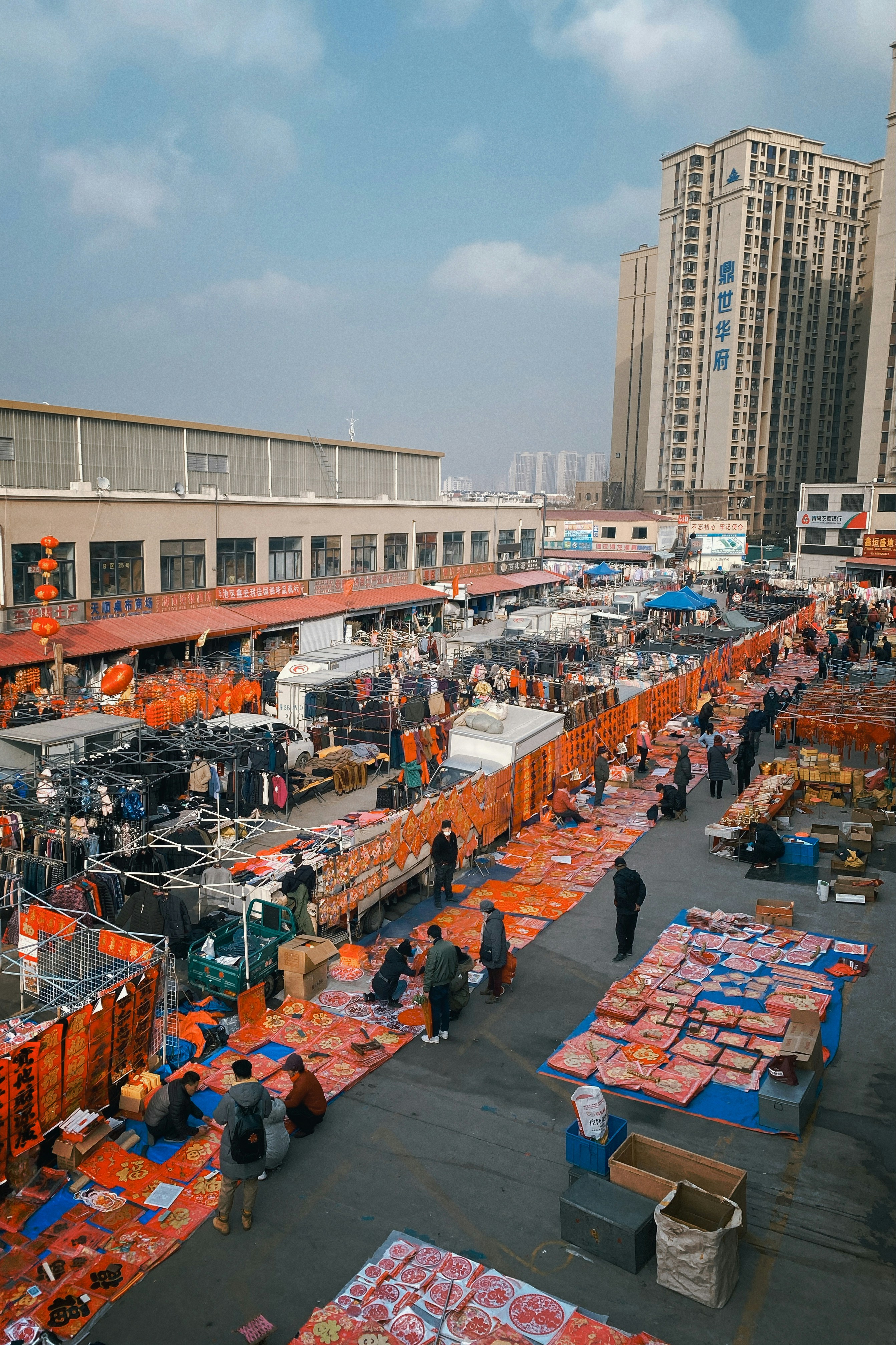 Bustling market filled with colorful displays of goods and vendors engaging with customers, showcasing a lively atmosphere. The scene captures the essence of local commerce.
