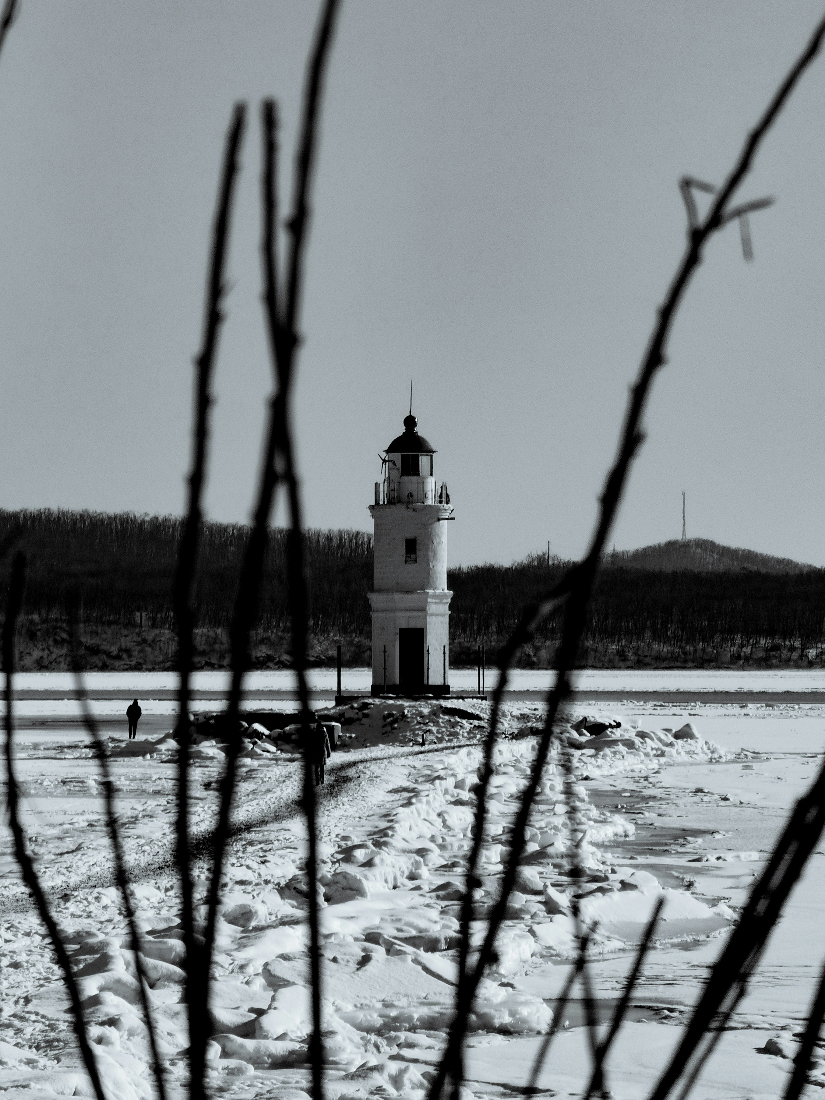 white and black lighthouse near body of water during daytime