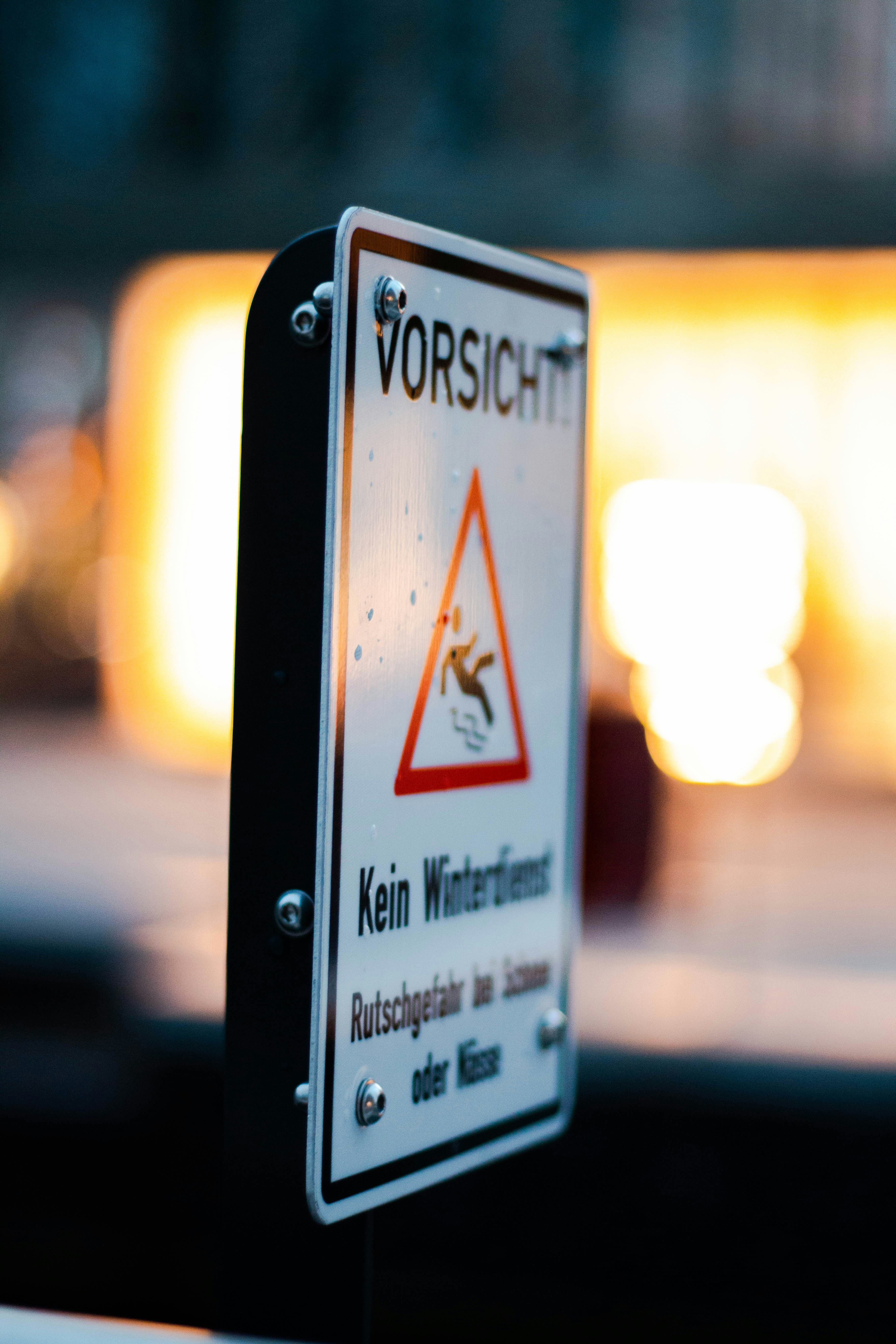 Tilted Vorsicht Sign Embraced by Neon Backlight