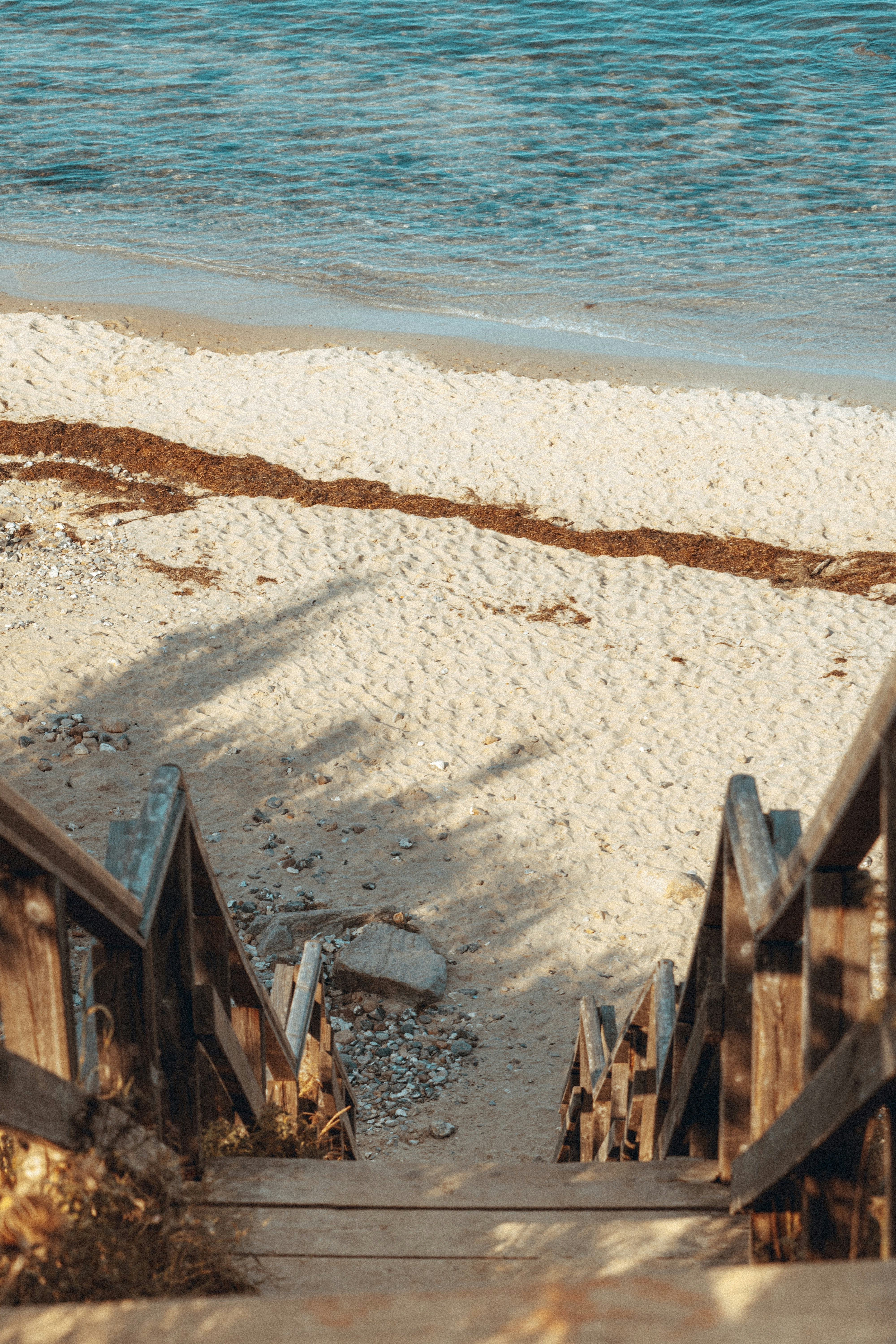 Weathered Wooden Steps Descend to a Turquoise Beach