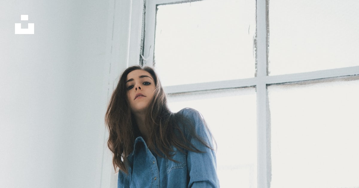 Woman In Blue Denim Jacket And White Denim Jeans Standing Beside White