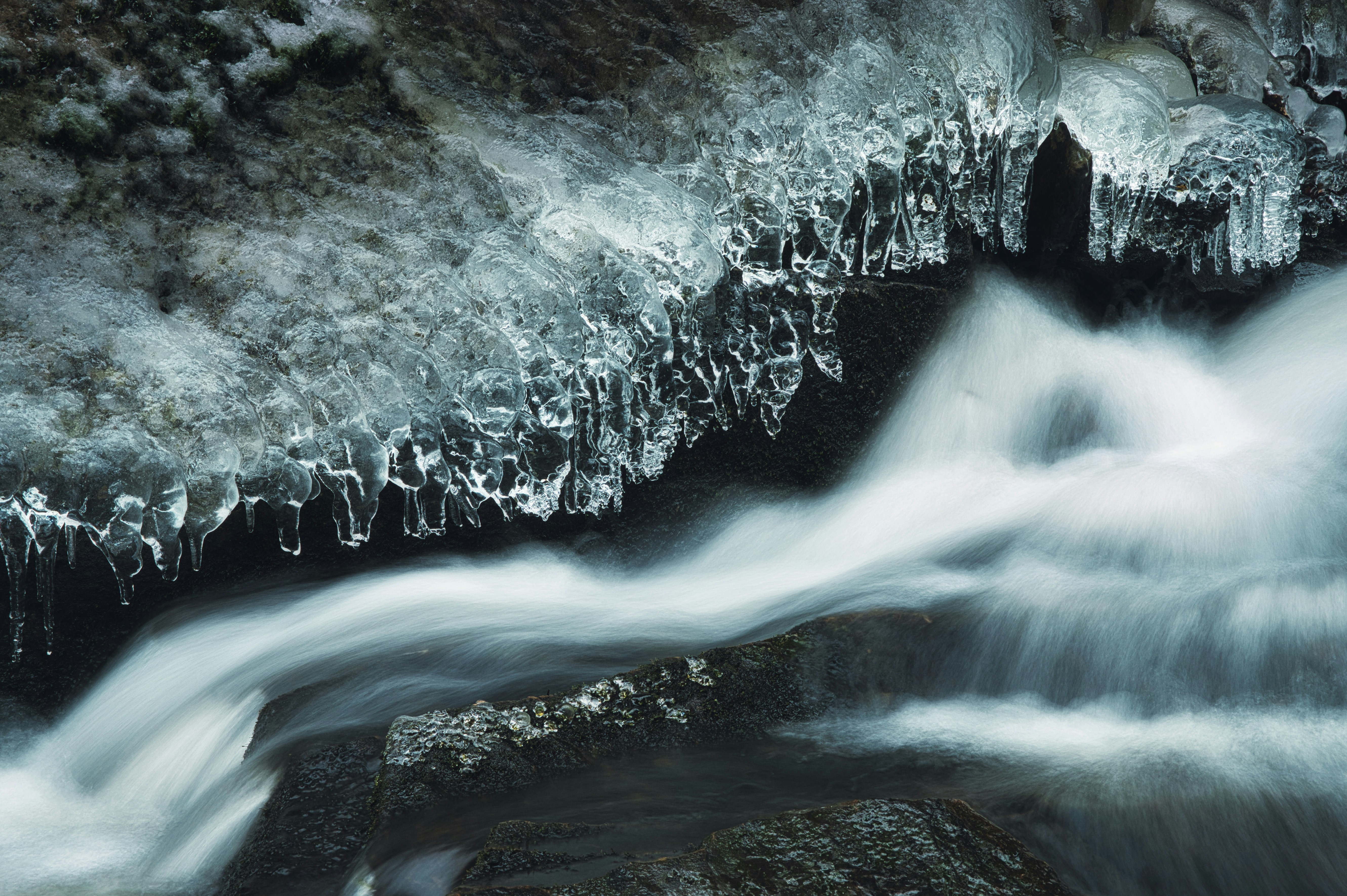 Icy Cascade: A Slender Ribbon of Water over Frigid Ledge