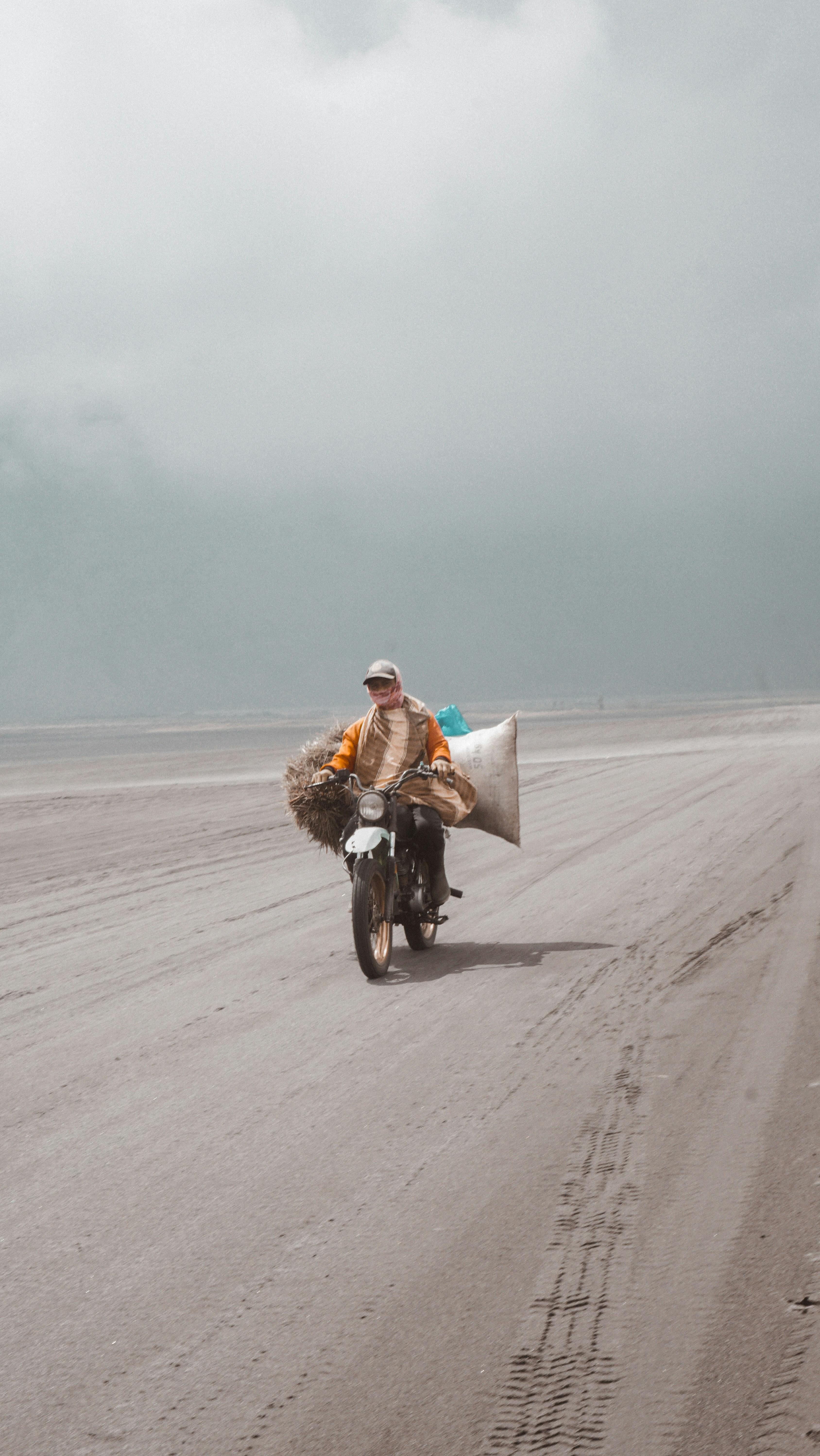 Dusty Road Rider: A Lone Motorcyclist with a Megaphone Cache