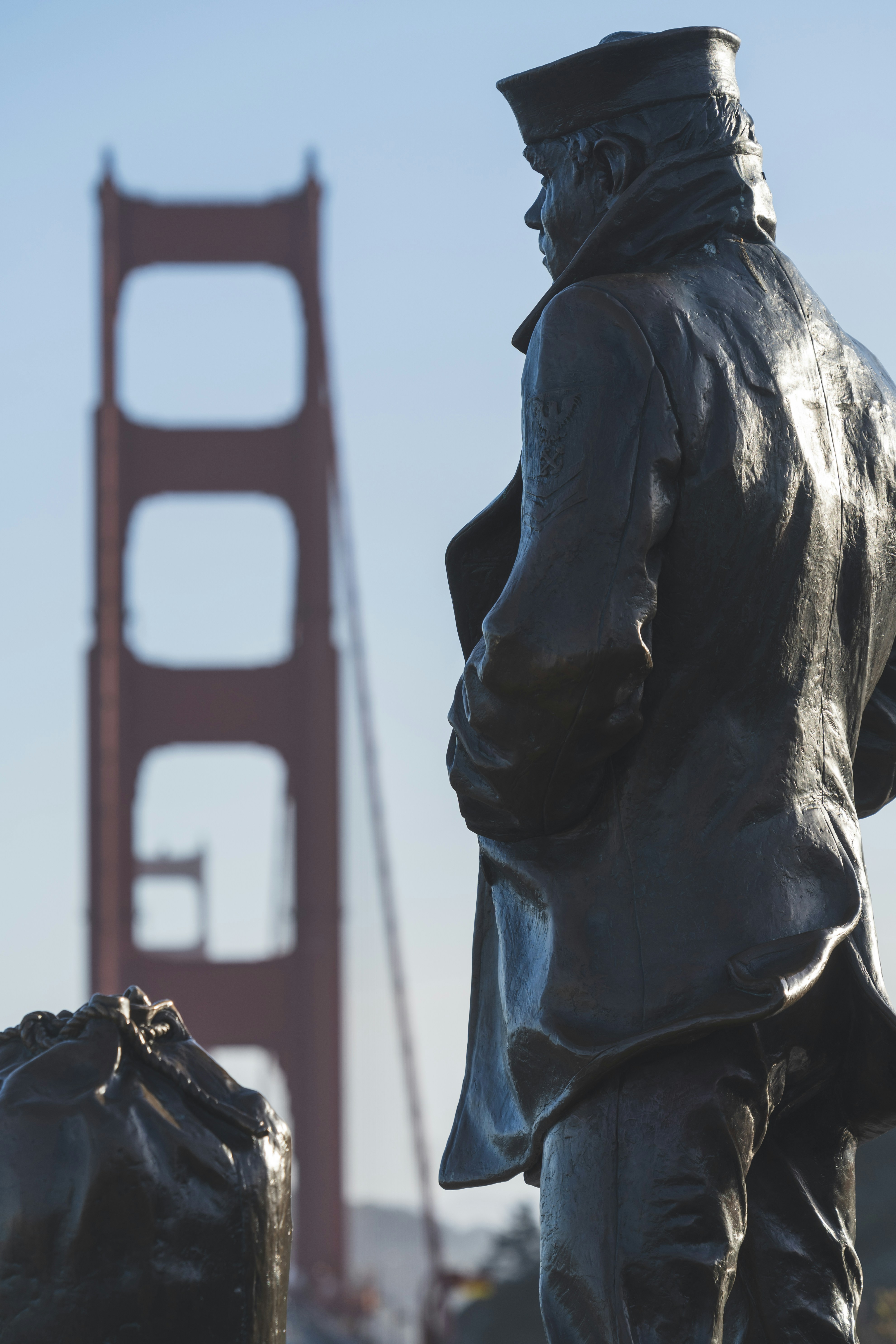 Bronze statue of a worker gazing towards the Golden Gate Bridge, symbolizing dedication and craftsmanship in construction.