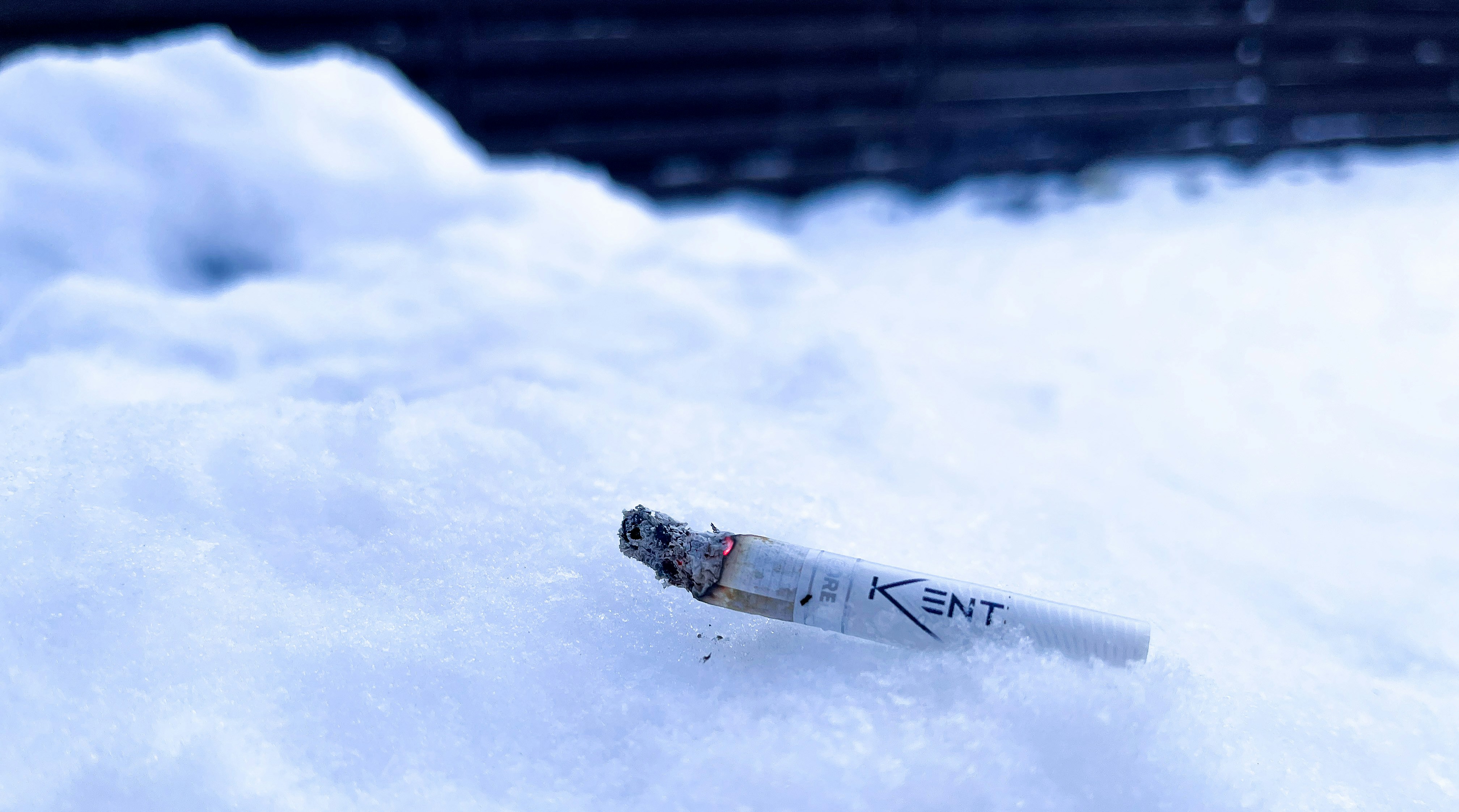 Snowlit Remnant: A Cigarette Half-Buried in Winter Quiet