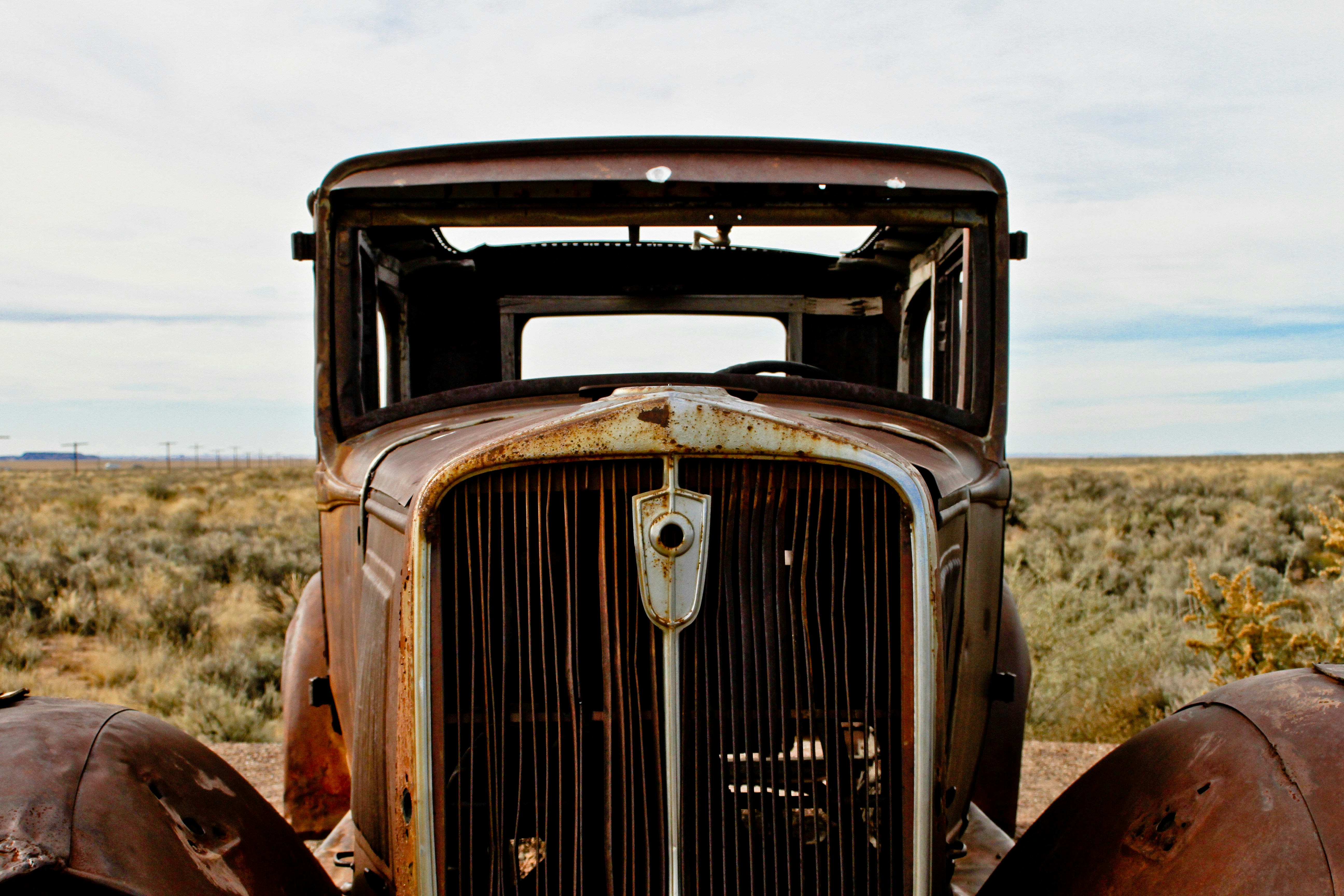 Rustbound Front in the Desert: A Vintage Car Faces the Empty Horizon