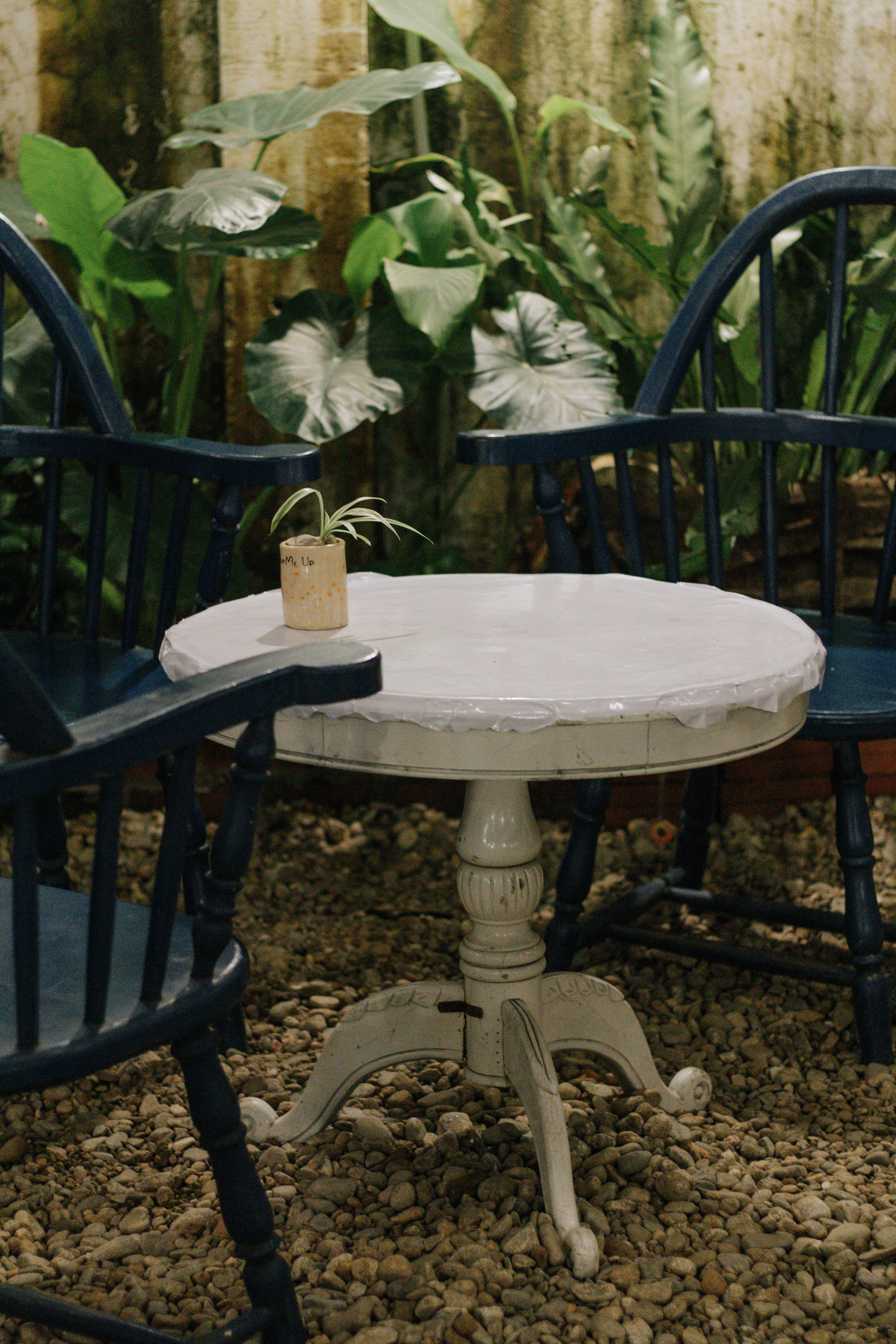 Tiny Plant Centerpiece on a White Round Table in a Pebble Courtyard