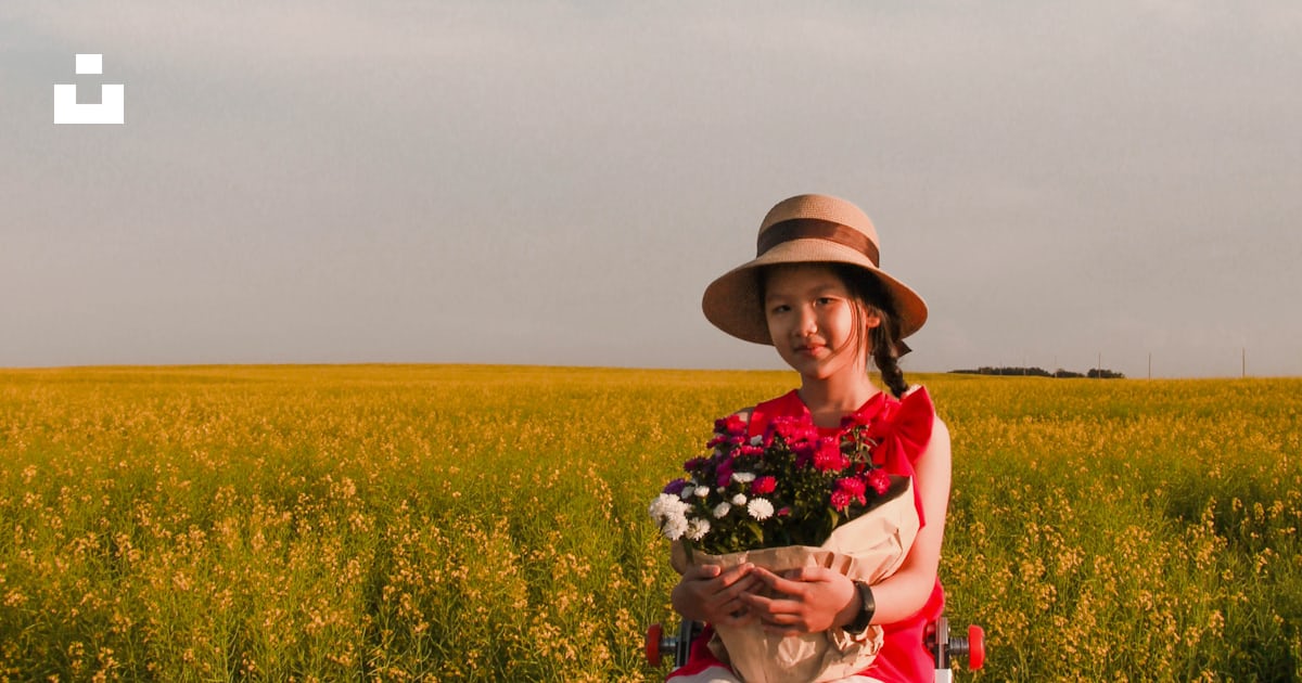 분홍색과 흰색 꽃 드레스를 입은 여자는 낮 동안 노란 꽃밭에 앉아 있다 사진 Unsplash의 무료 꽃 이미지