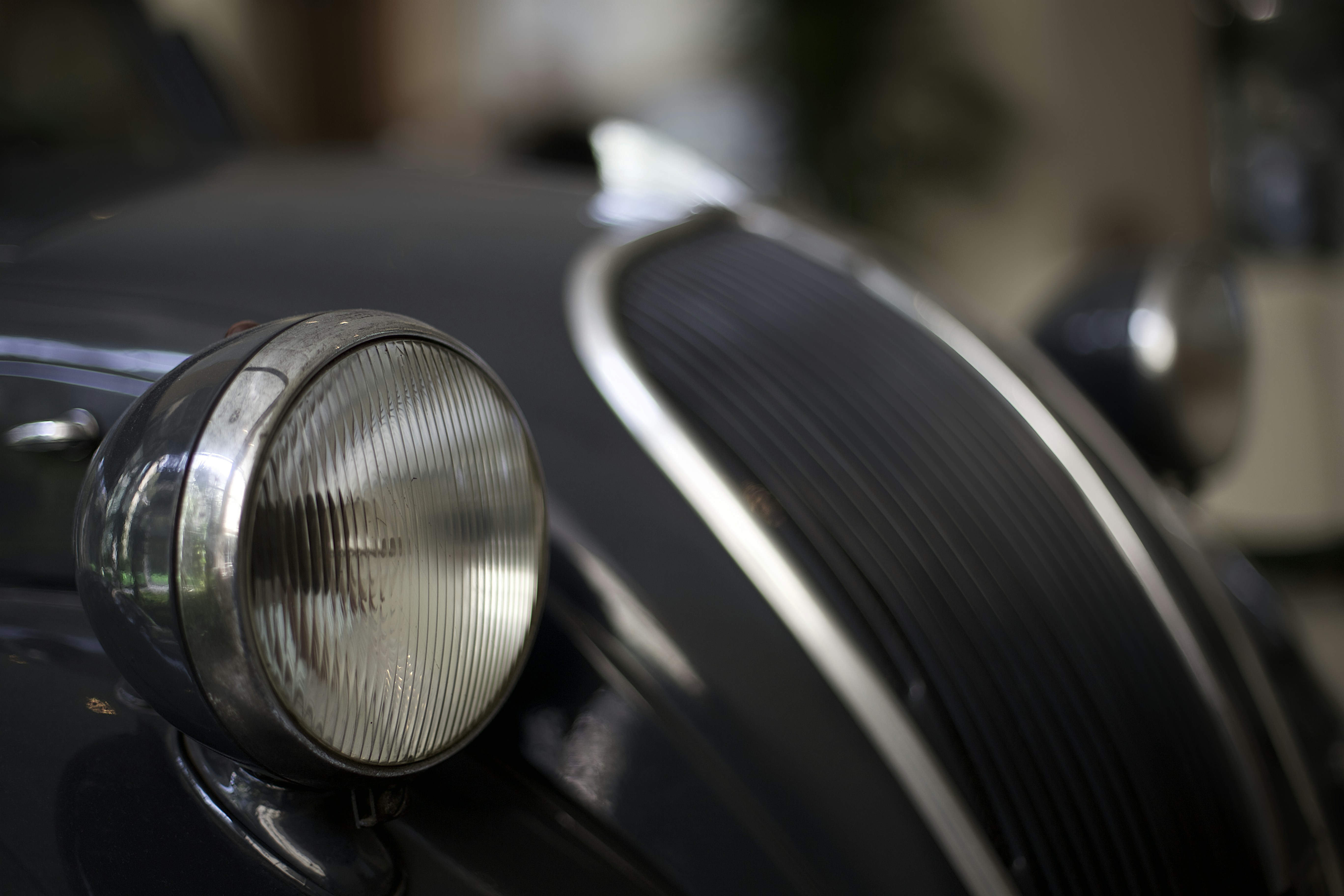 Vintage Headlight Gaze: A Close-Up of Classic Car Grille and Lamp