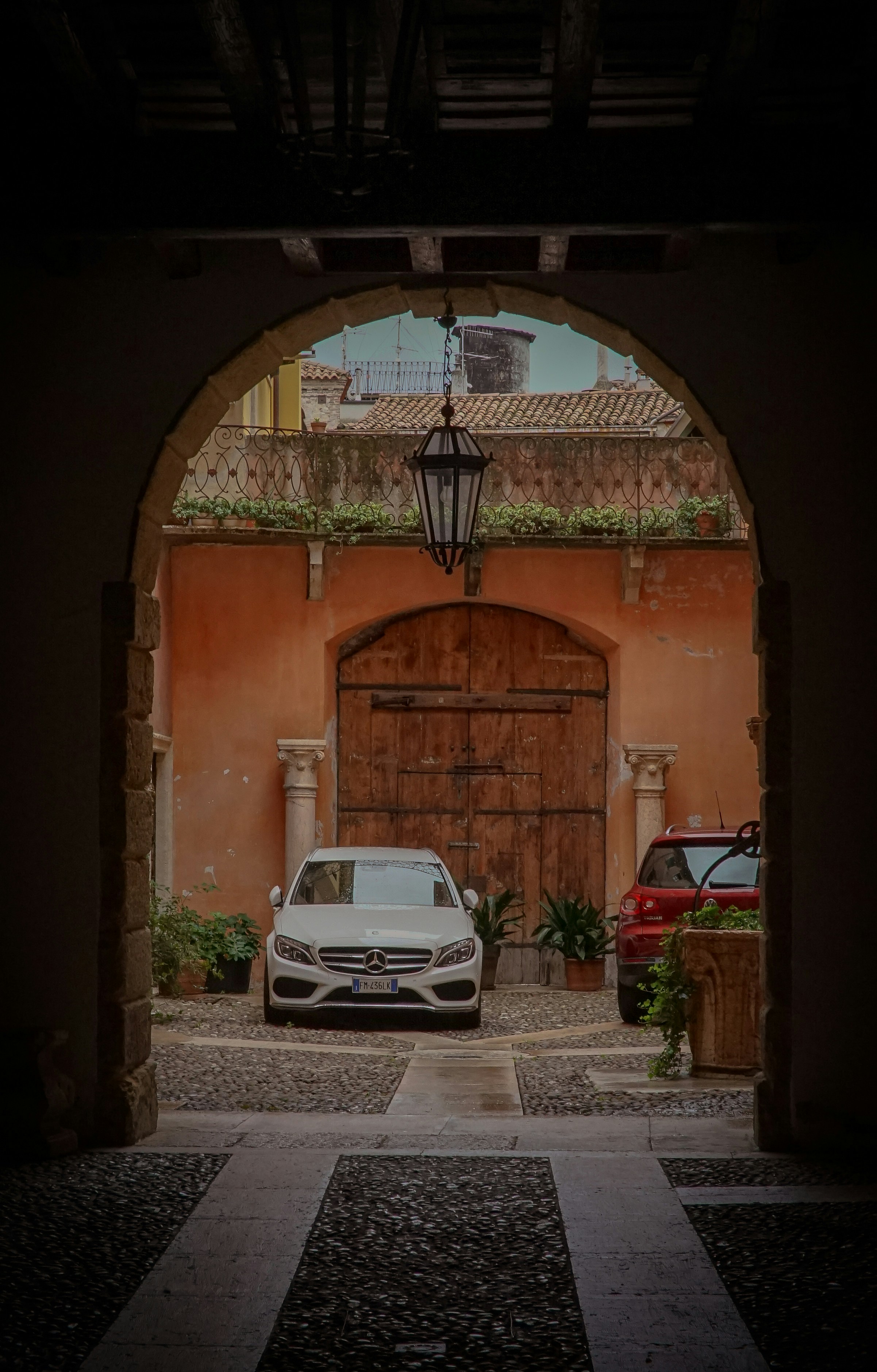 Cloister Archway Portrait: A Mercedes Graces the Courtyard Gate