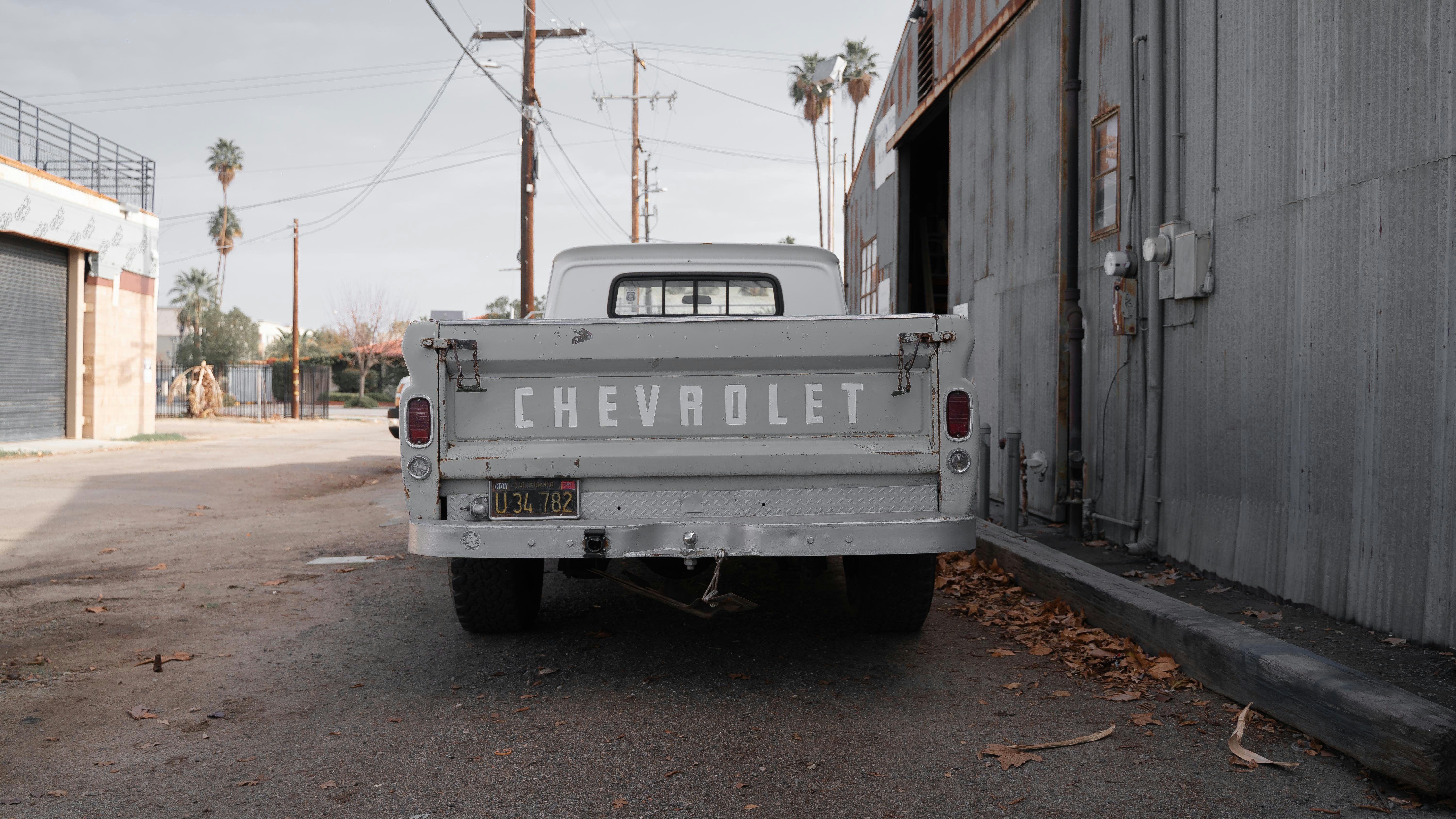 Classic Chevrolet truck parked in an urban alley, showcasing its vintage charm against a backdrop of industrial textures.