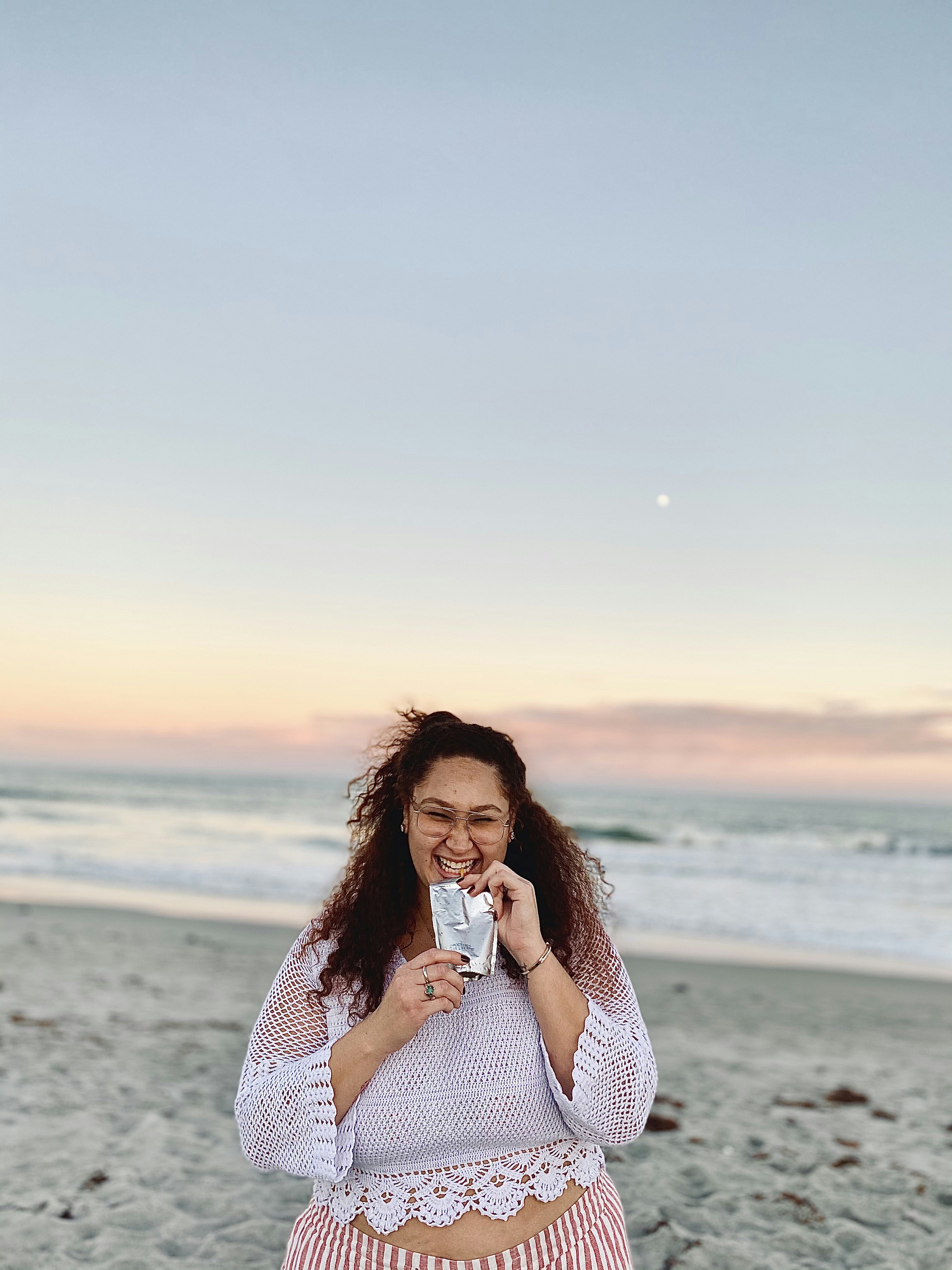 Dusk by the Shore: Laughing with a Snack as Pastel Skies Glow