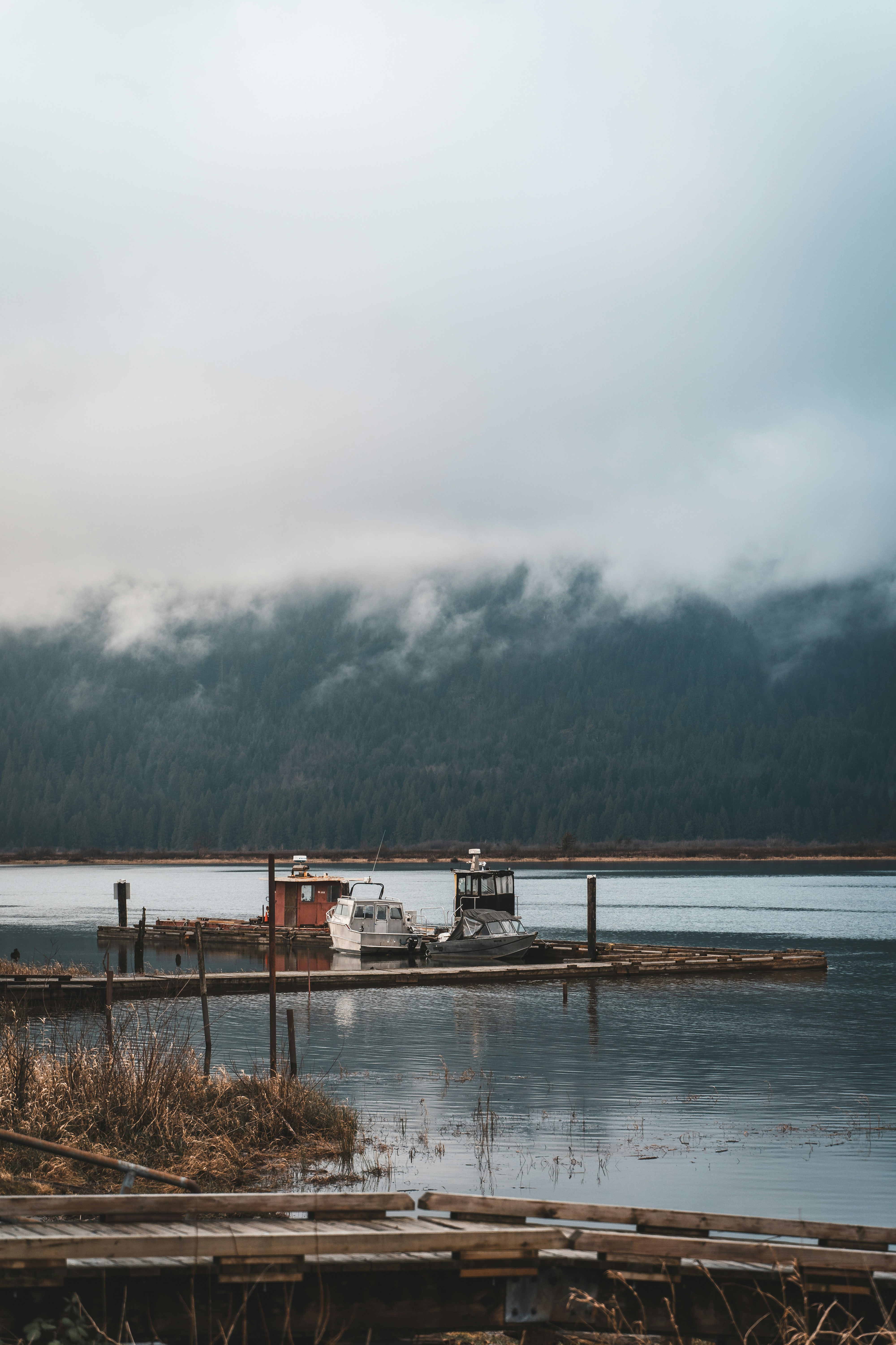 Docked Boats Beneath a Misty Mountain Crest