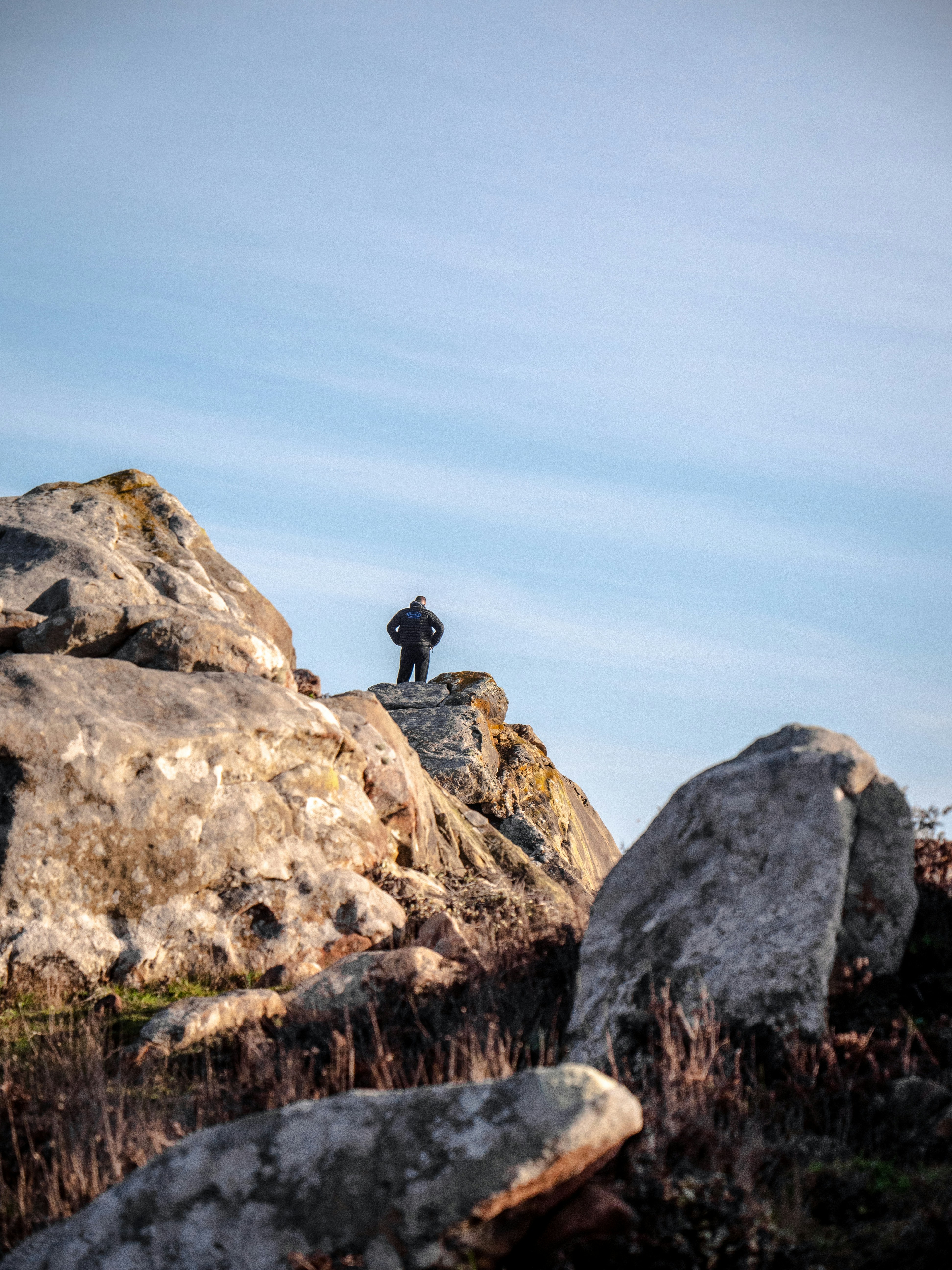 Solitary Climber on Weathered Granite Under a Broad Blue Sky