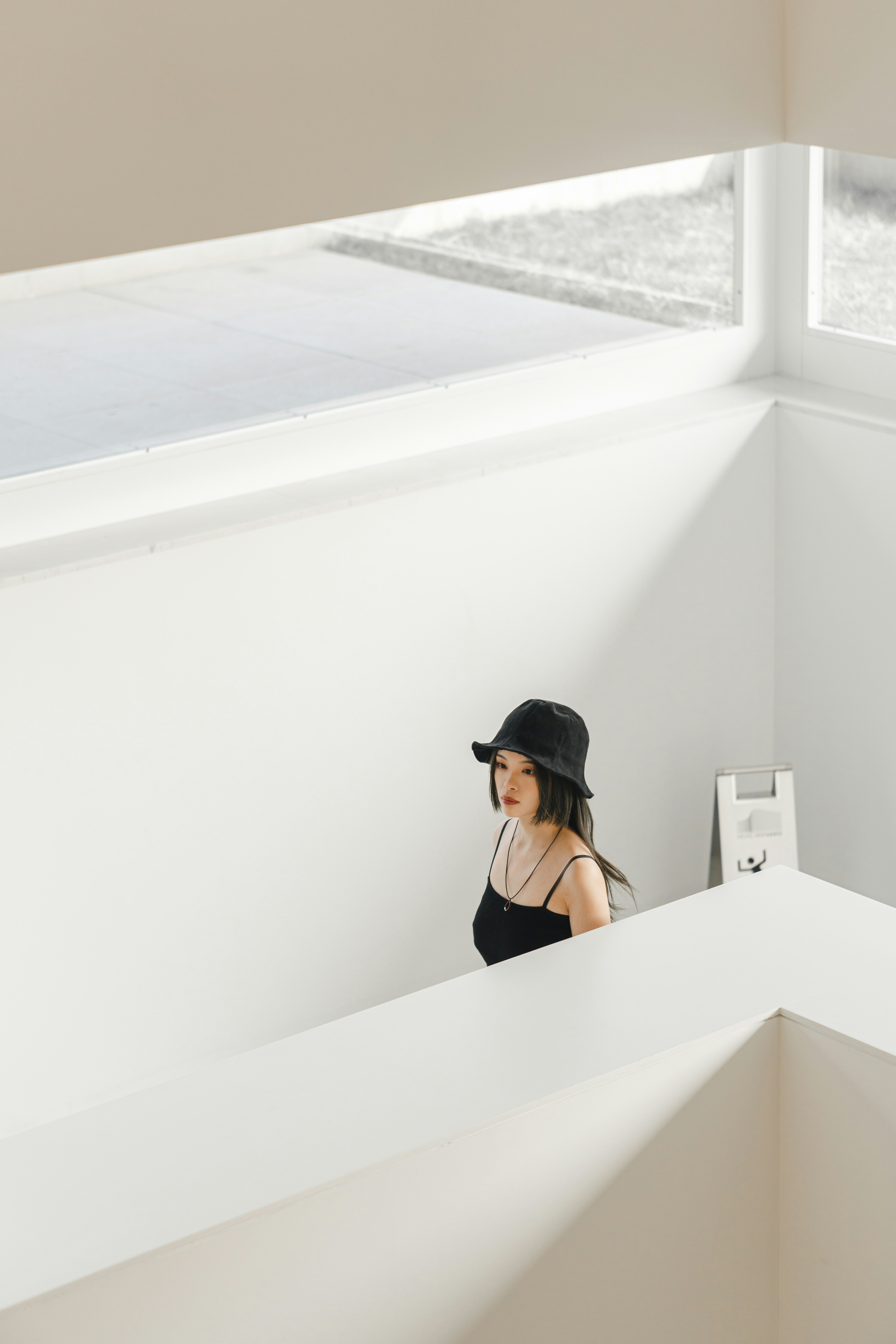 Solo in White: Portrait within a Sunlit Atrium
