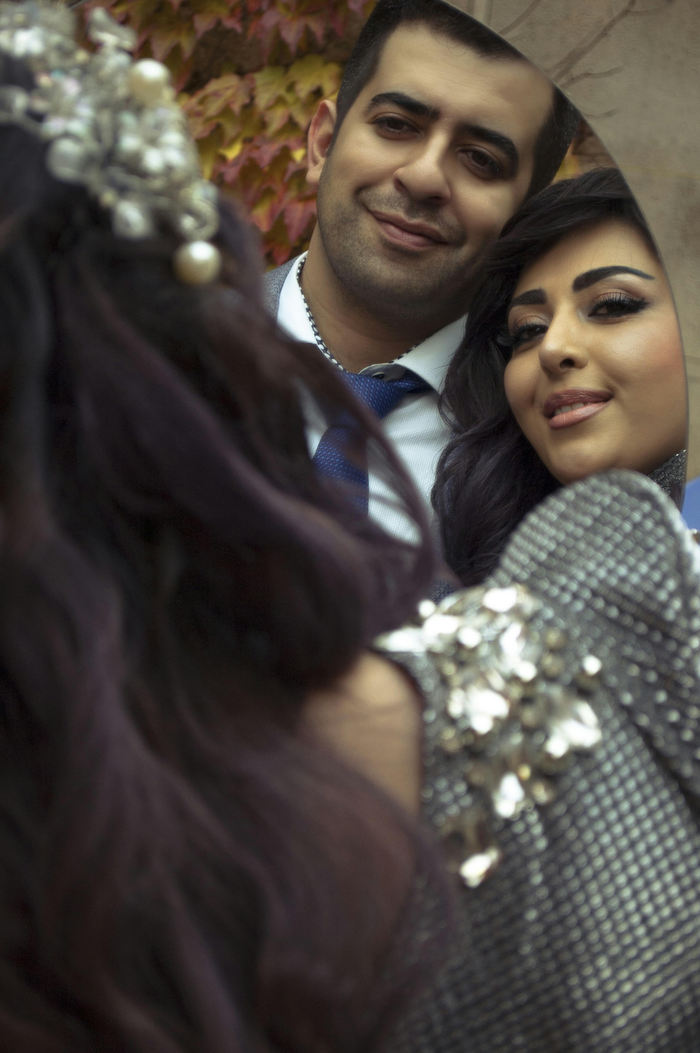 woman in black and white polka dot dress smiling beside man in black suit
