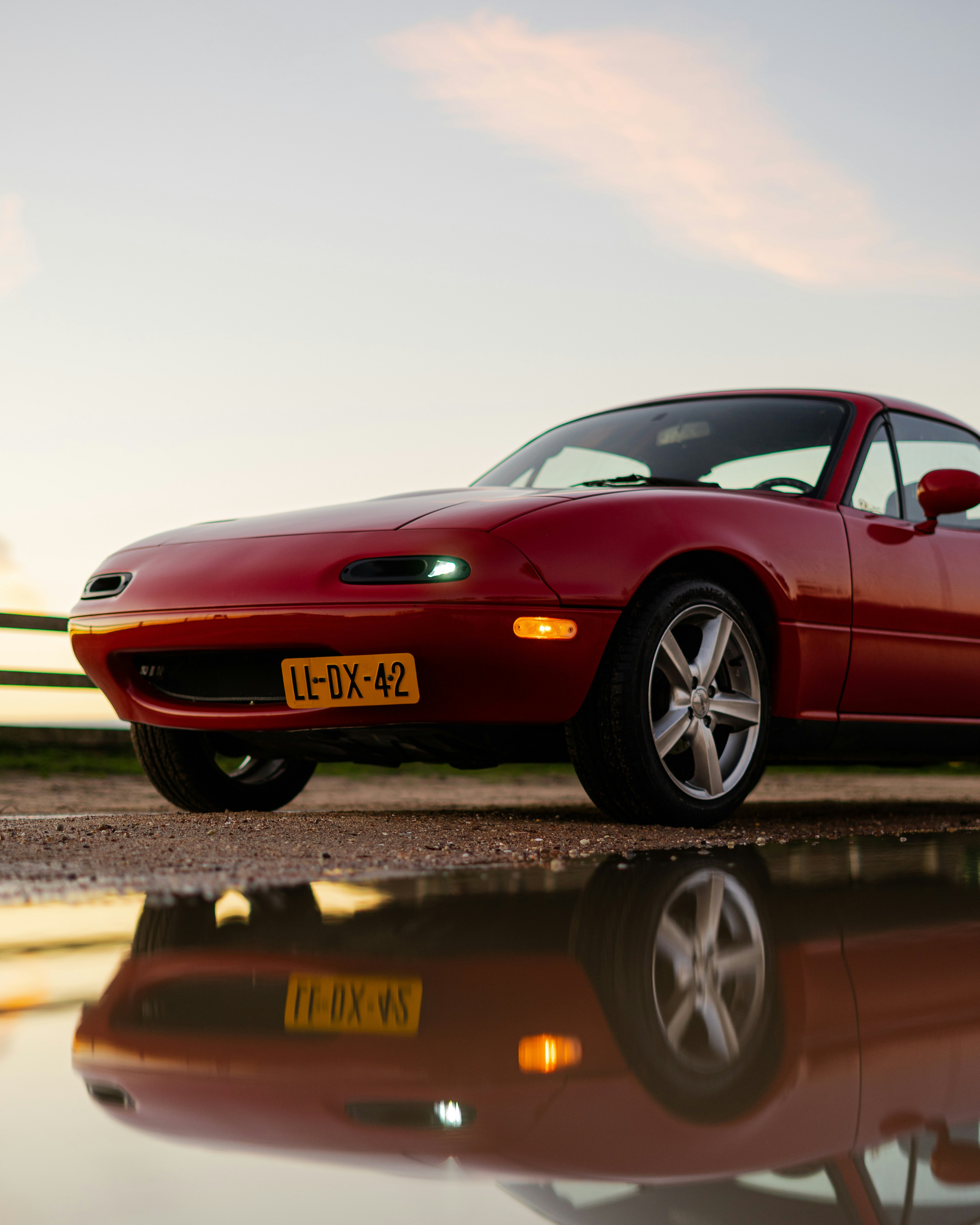 Dusk-Glazed Red Miata: A Wet-Pavement Reflection Portrait
