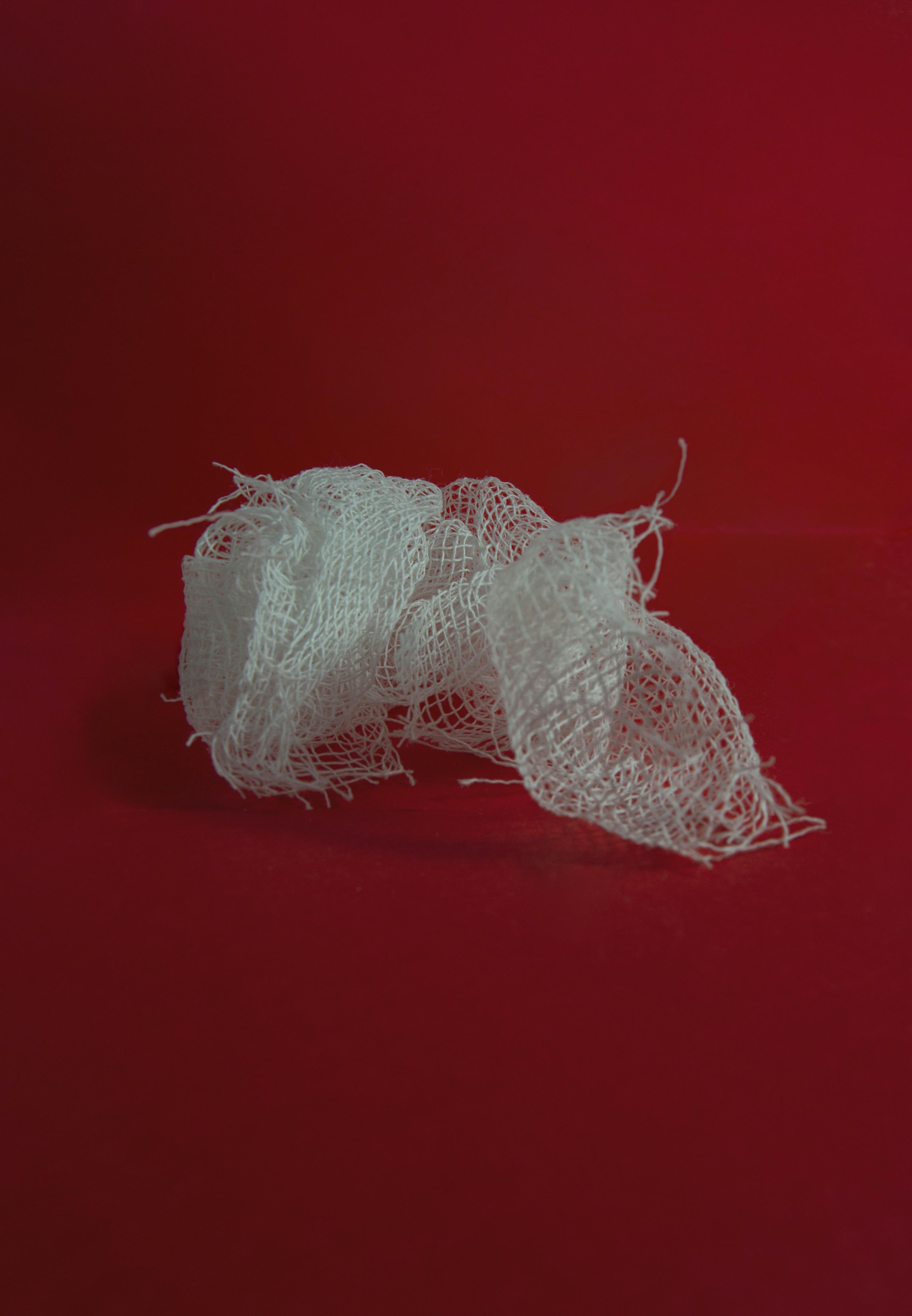 White Mesh Coil on Crimson Backdrop