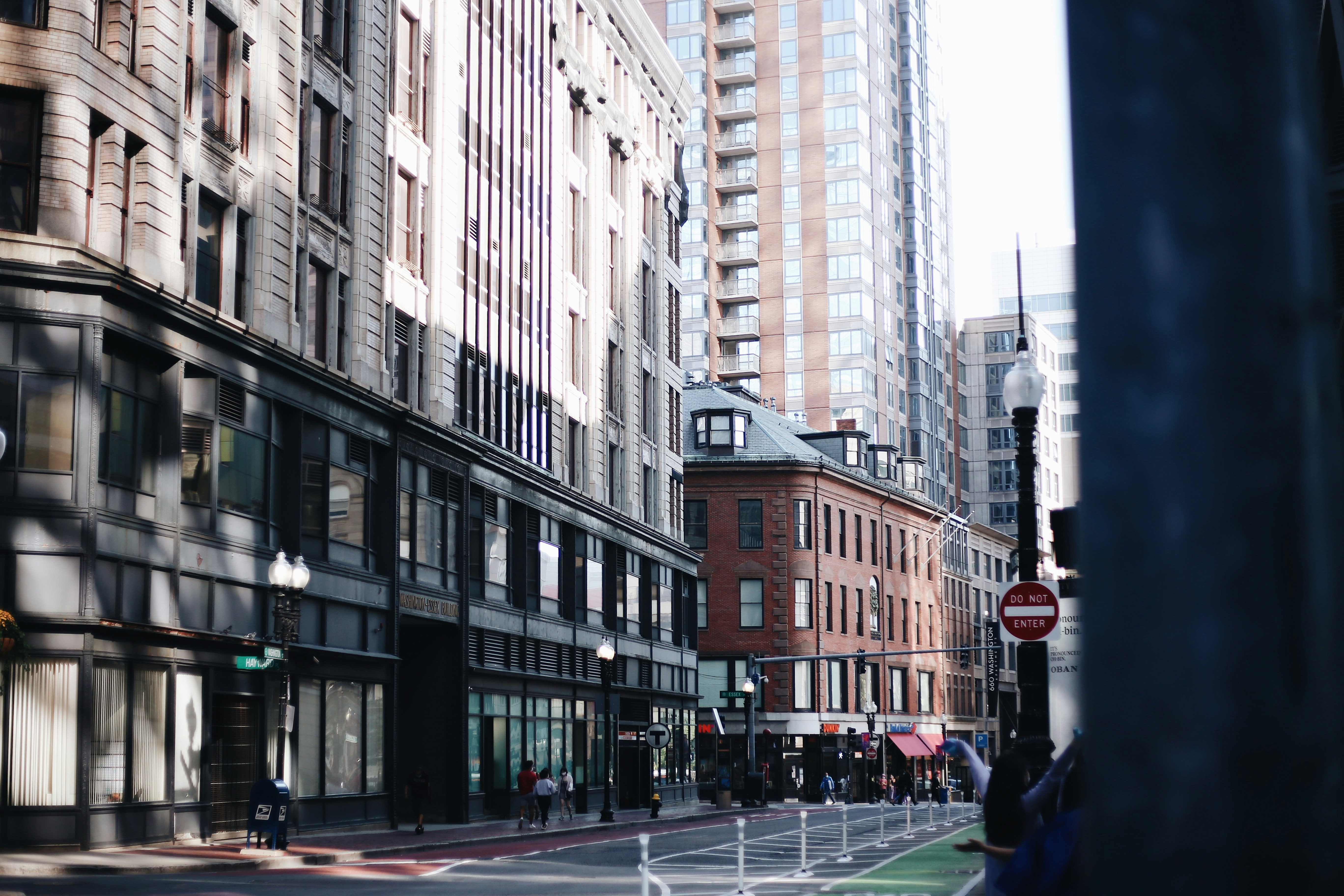 People walking on sidewalk near high rise buildings during daytime ...