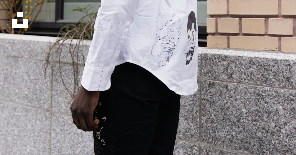 Man In White Long Sleeve Shirt And Black Pants Standing Beside Brown