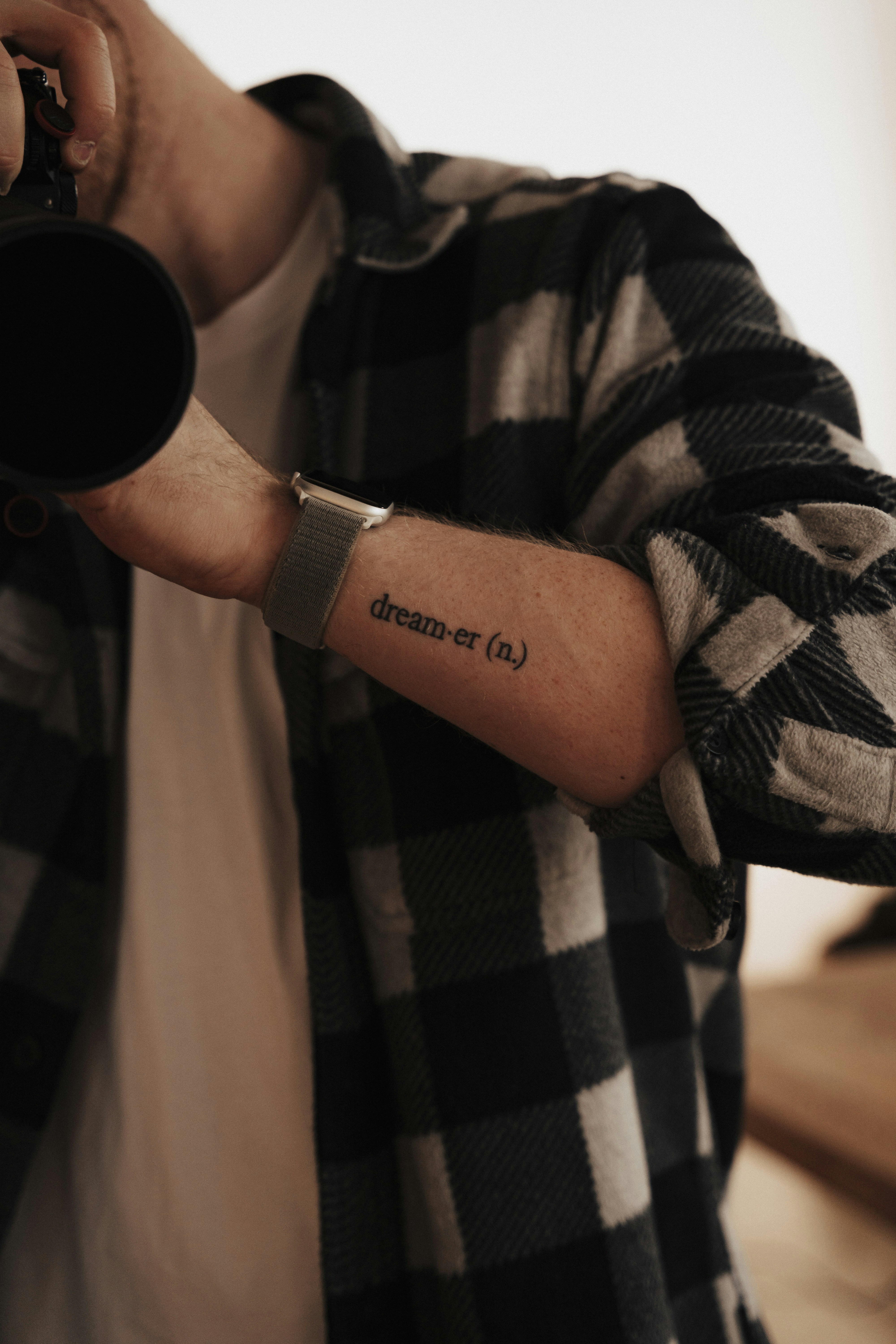 Man in black and white checkered dress shirt holding black ceramic mug ...