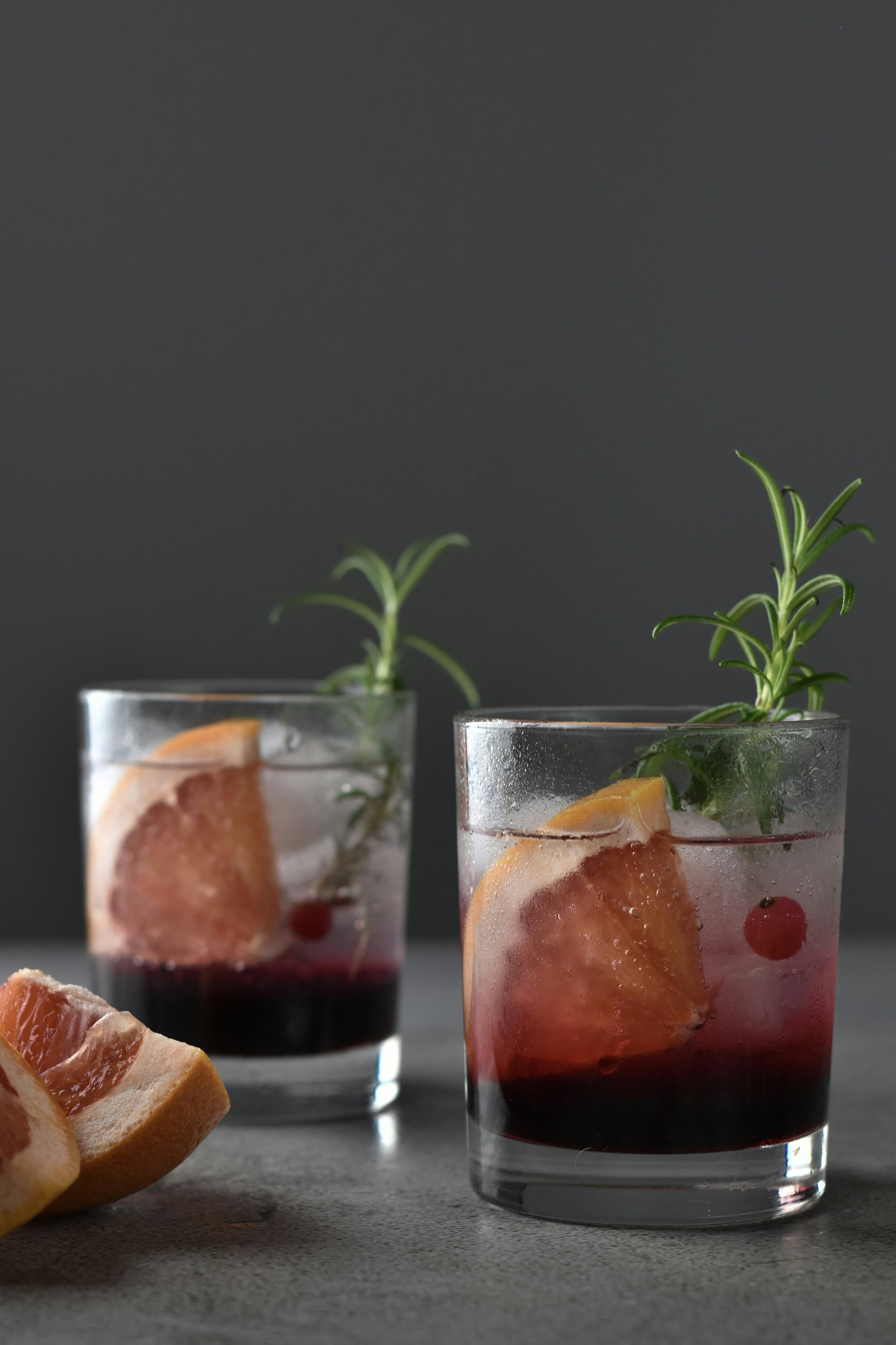 Rosemary-Garnished Citrus Spritz Duo on a Dark Studio Counter