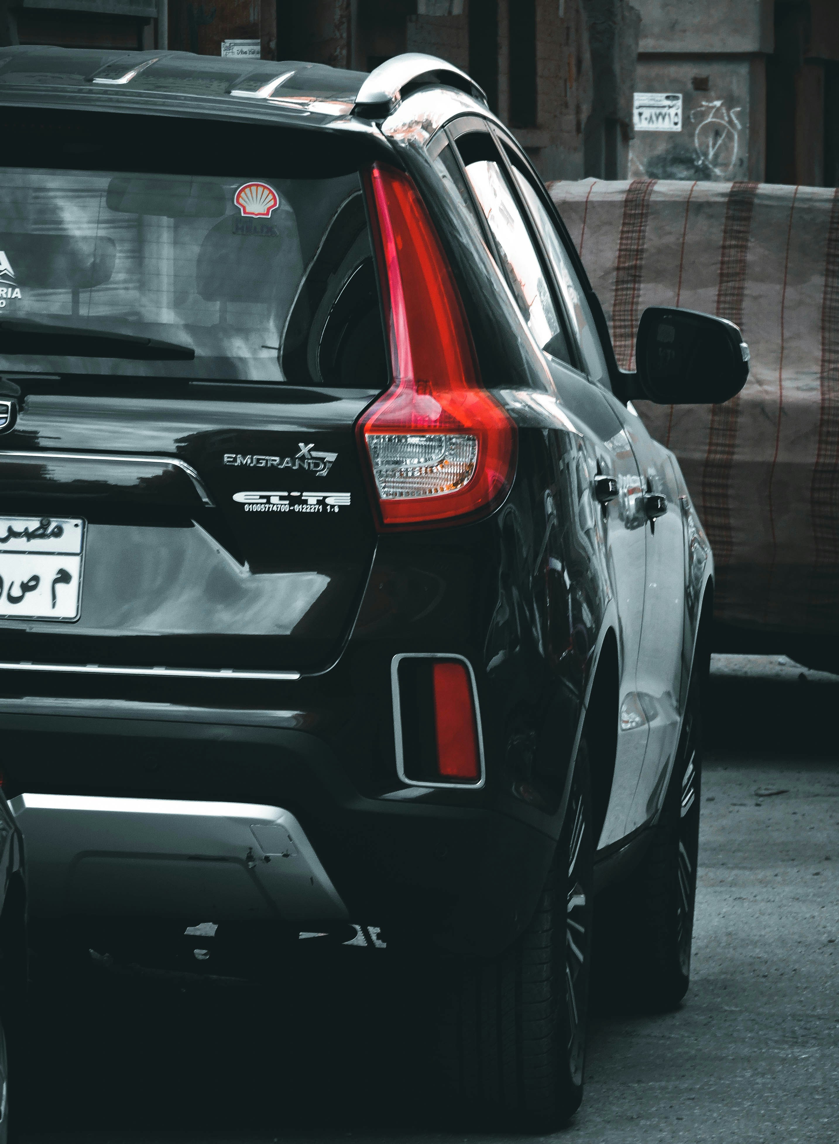 Tail Light Portrait of a Black SUV Against an Urban Brick Backdrop