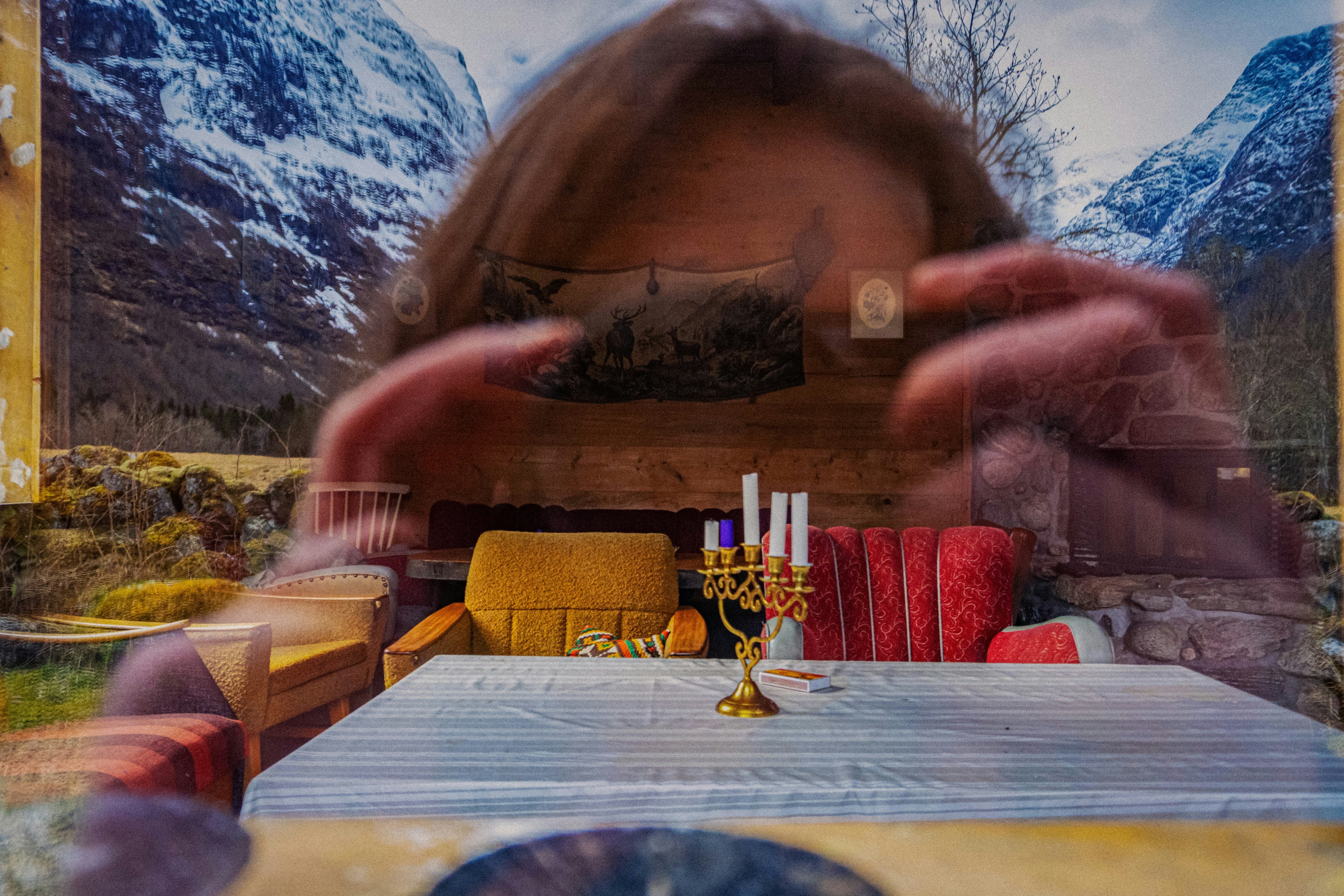 Alpine Reflections: Candlelit Table Through Glass