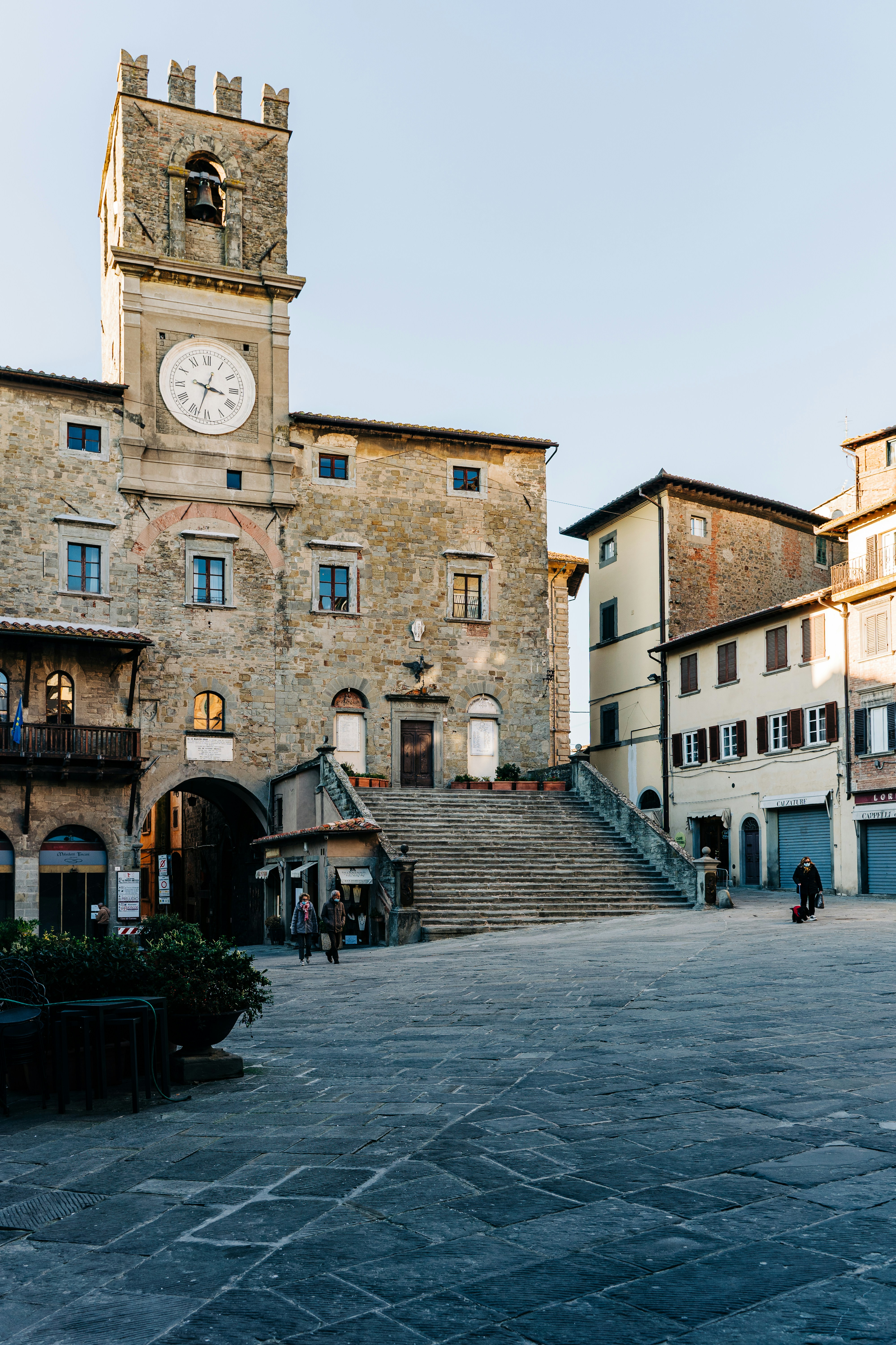 The main square in Cortona, Tuscany, Italy | people walking on sidewalk near brown concrete building during daytime