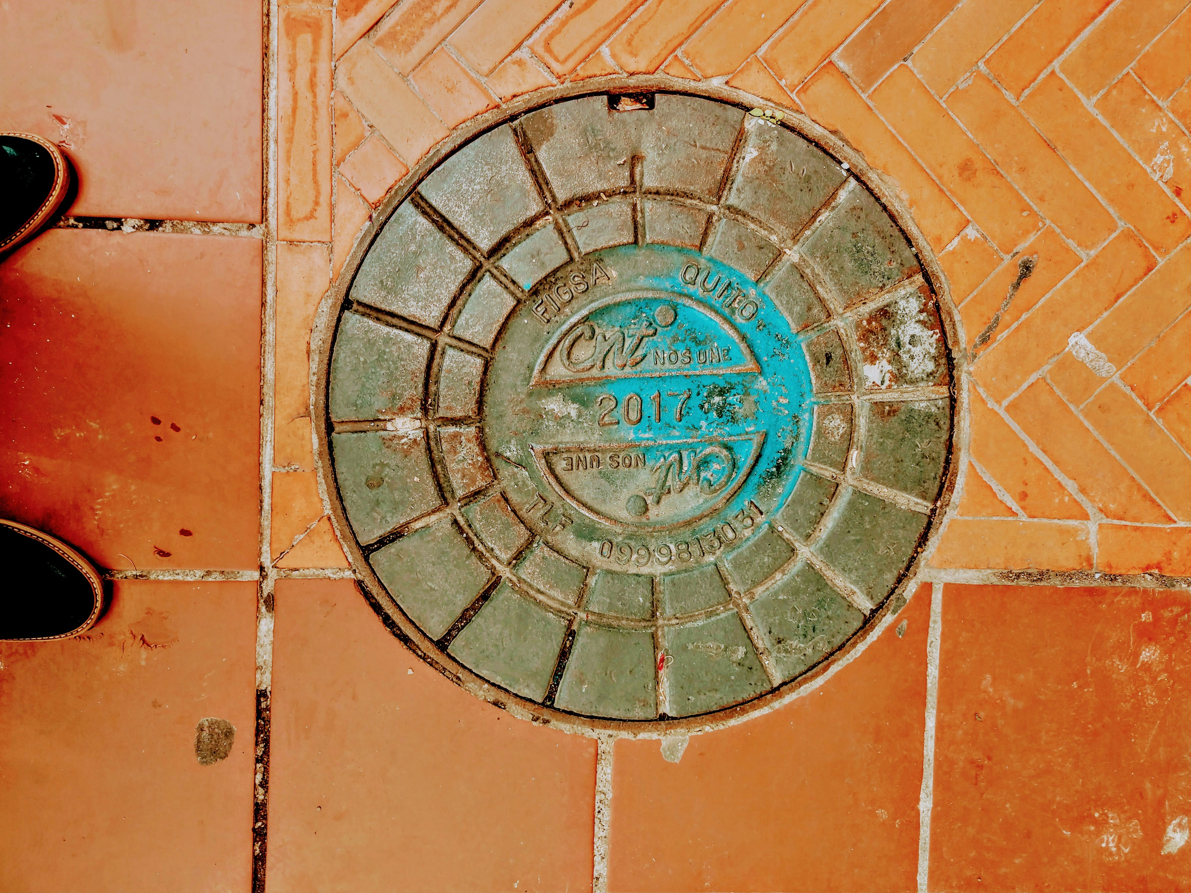 Central Manhole Anchored in a Rust-Orange Tile Grid