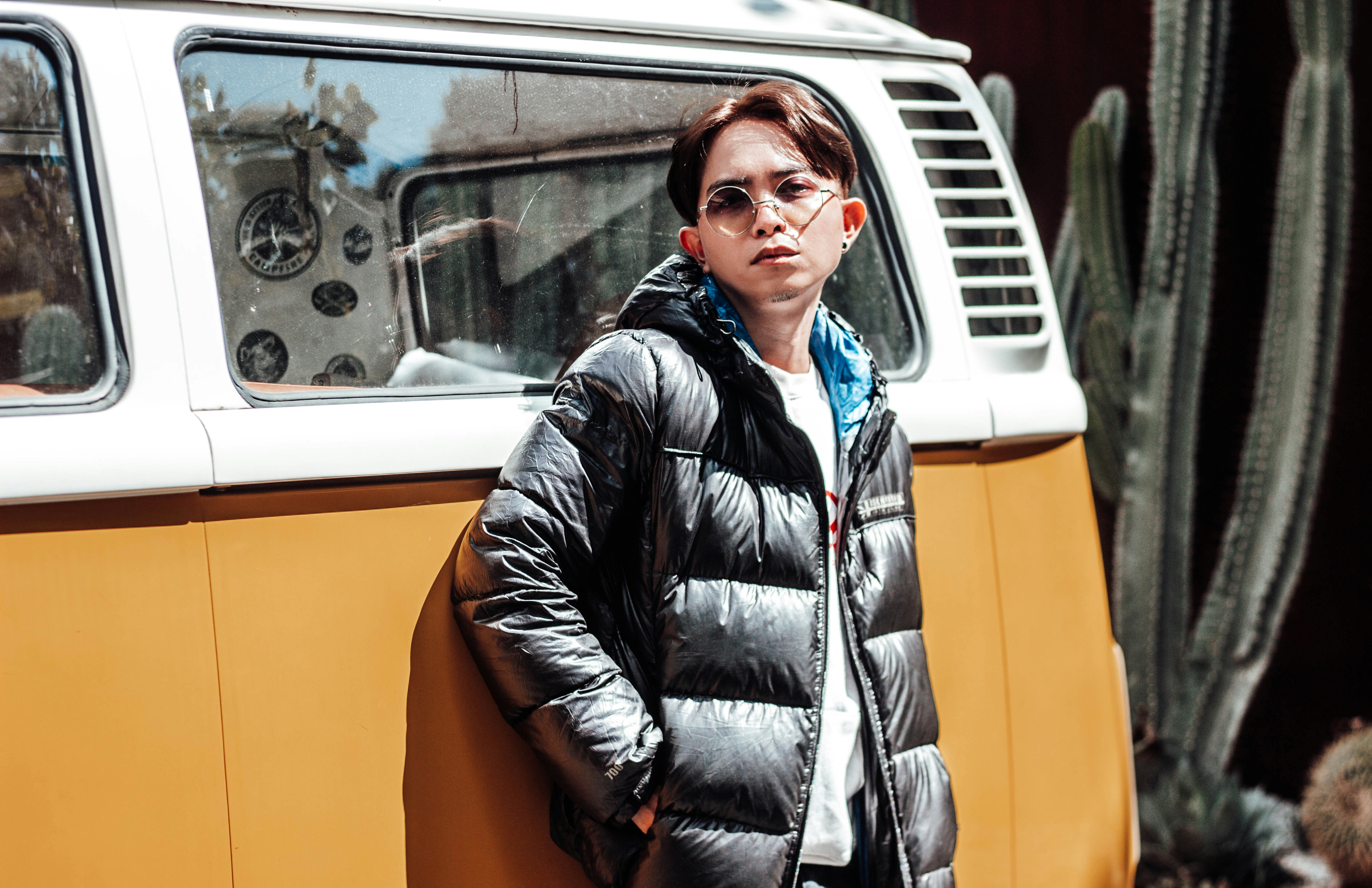 woman in black bubble jacket standing beside yellow car during daytime