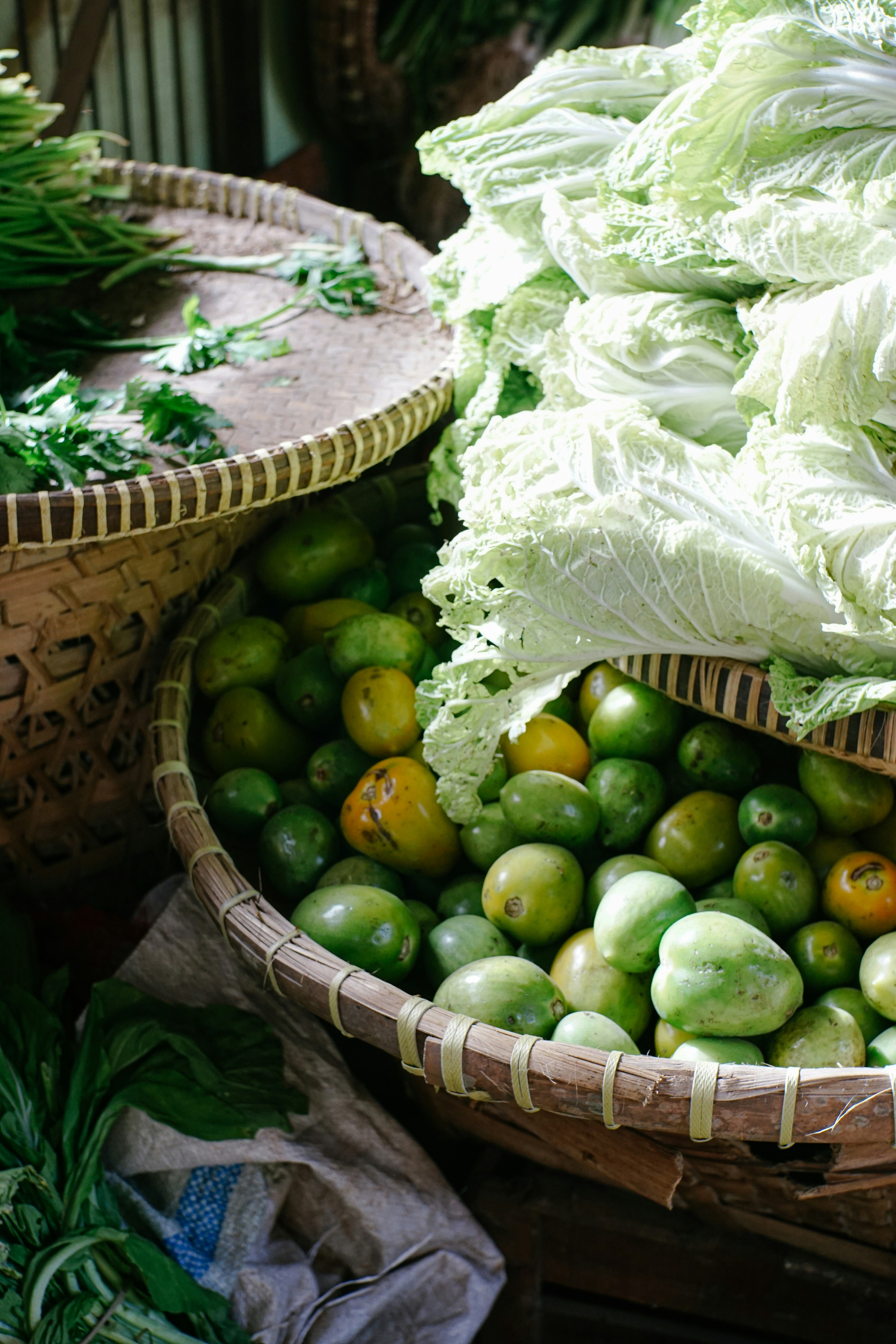 green fruits on brown woven basket
