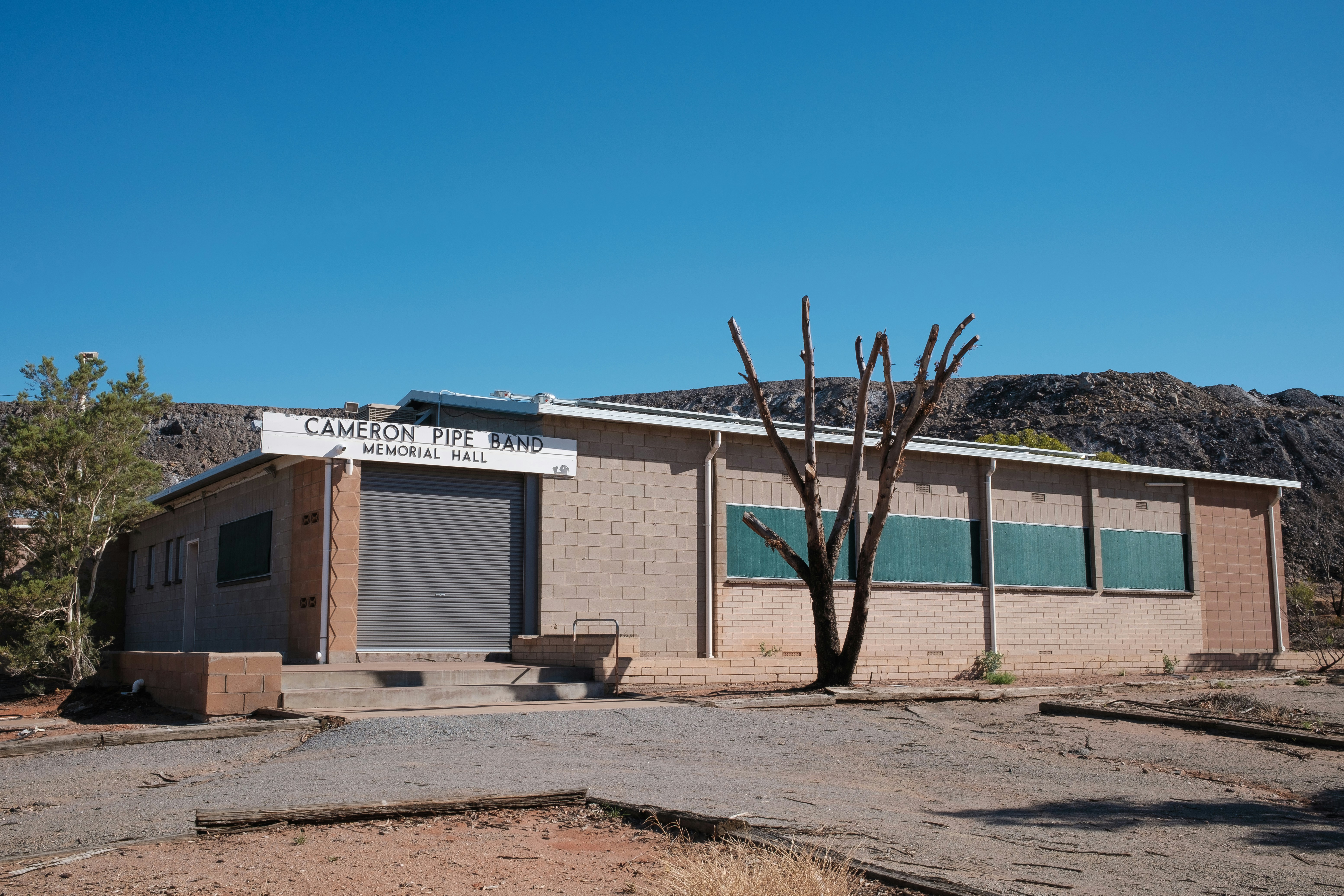 Sun-baked relic: Cameron Pipe Memorial Hall under a cobalt desert sky