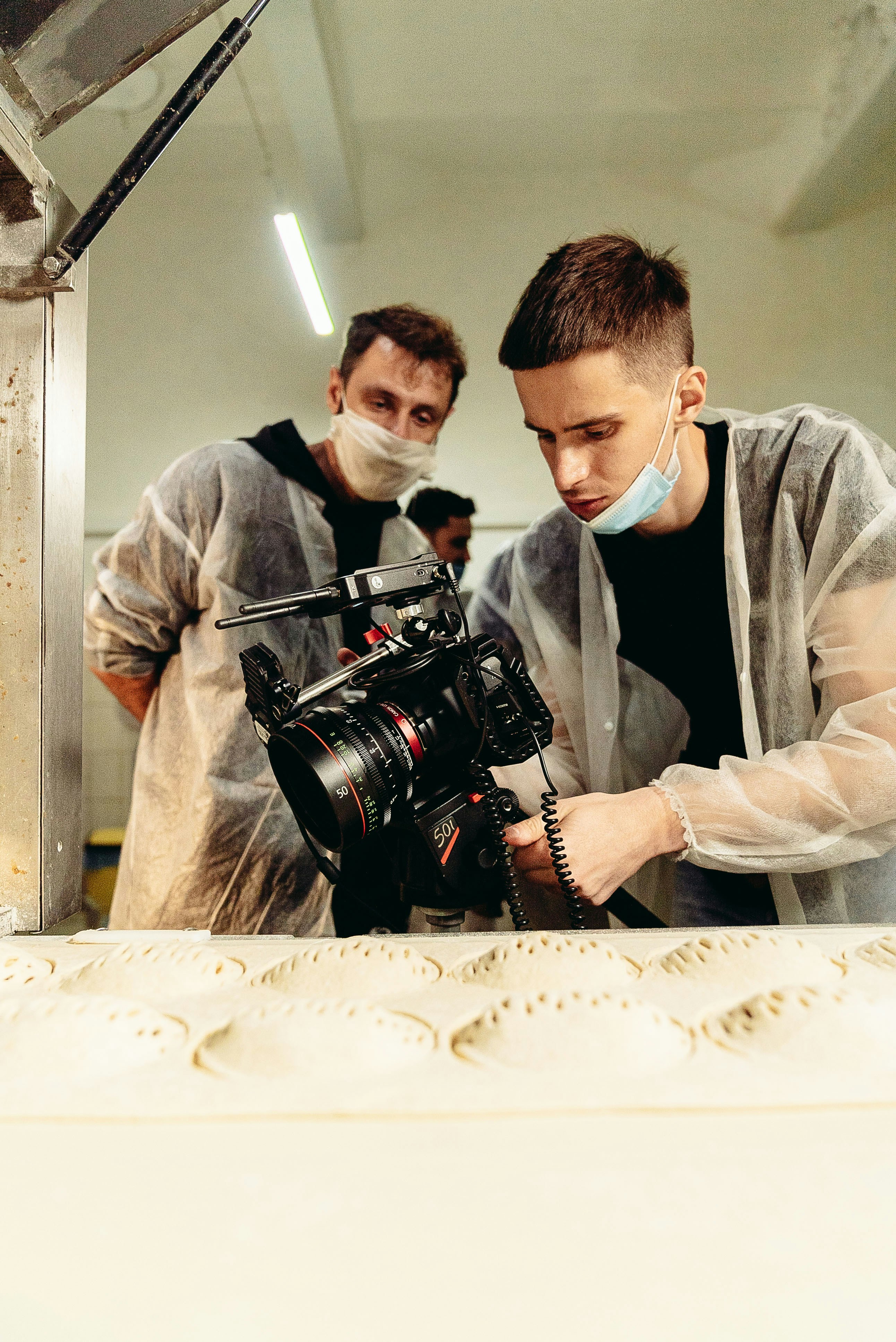 Behind the Lens: Two Technicians Calibrating a Cine Rig in a Sunlit Workshop
