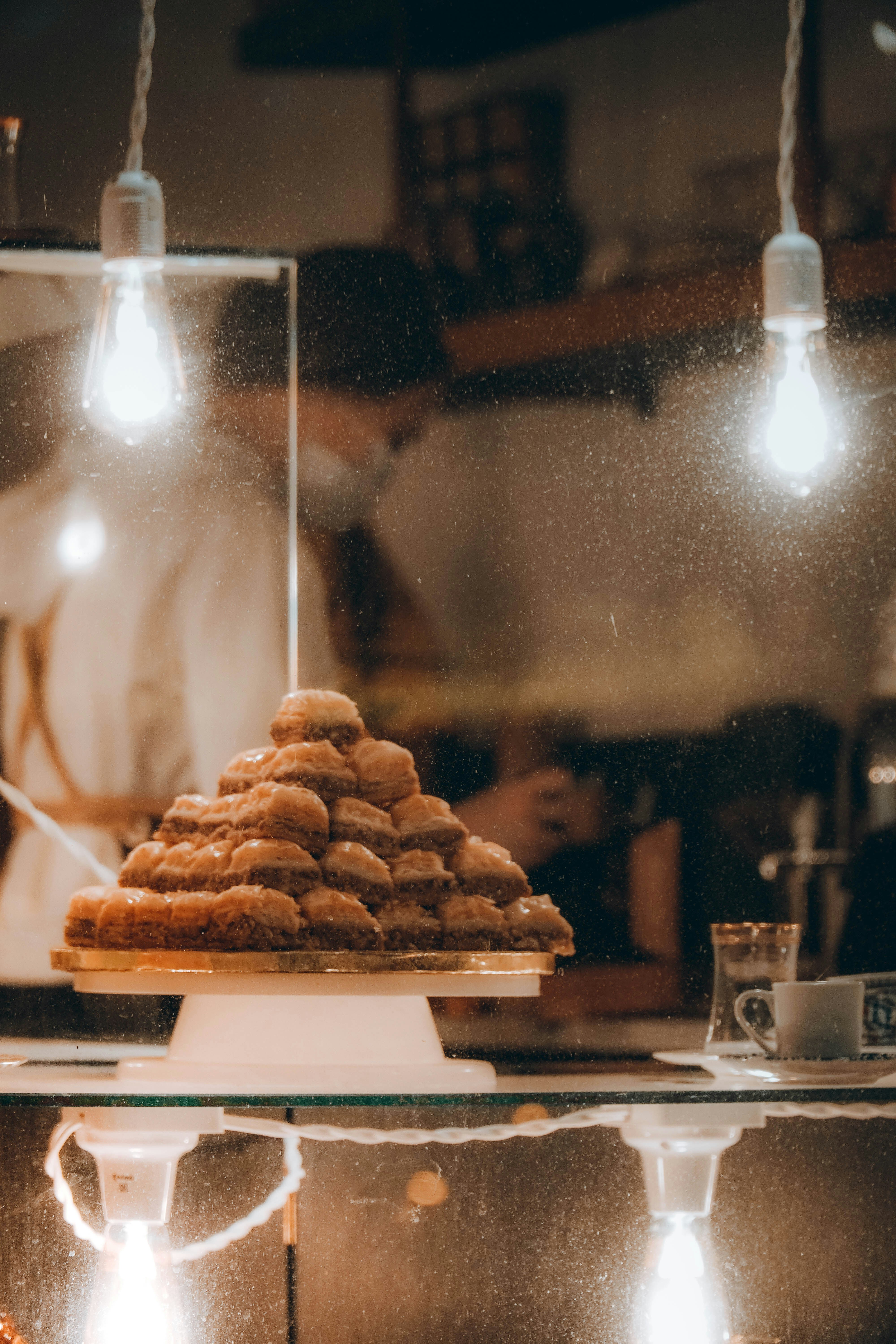 Amber Glow Illuminates a Pastry Pyramid in a Quiet Bakery