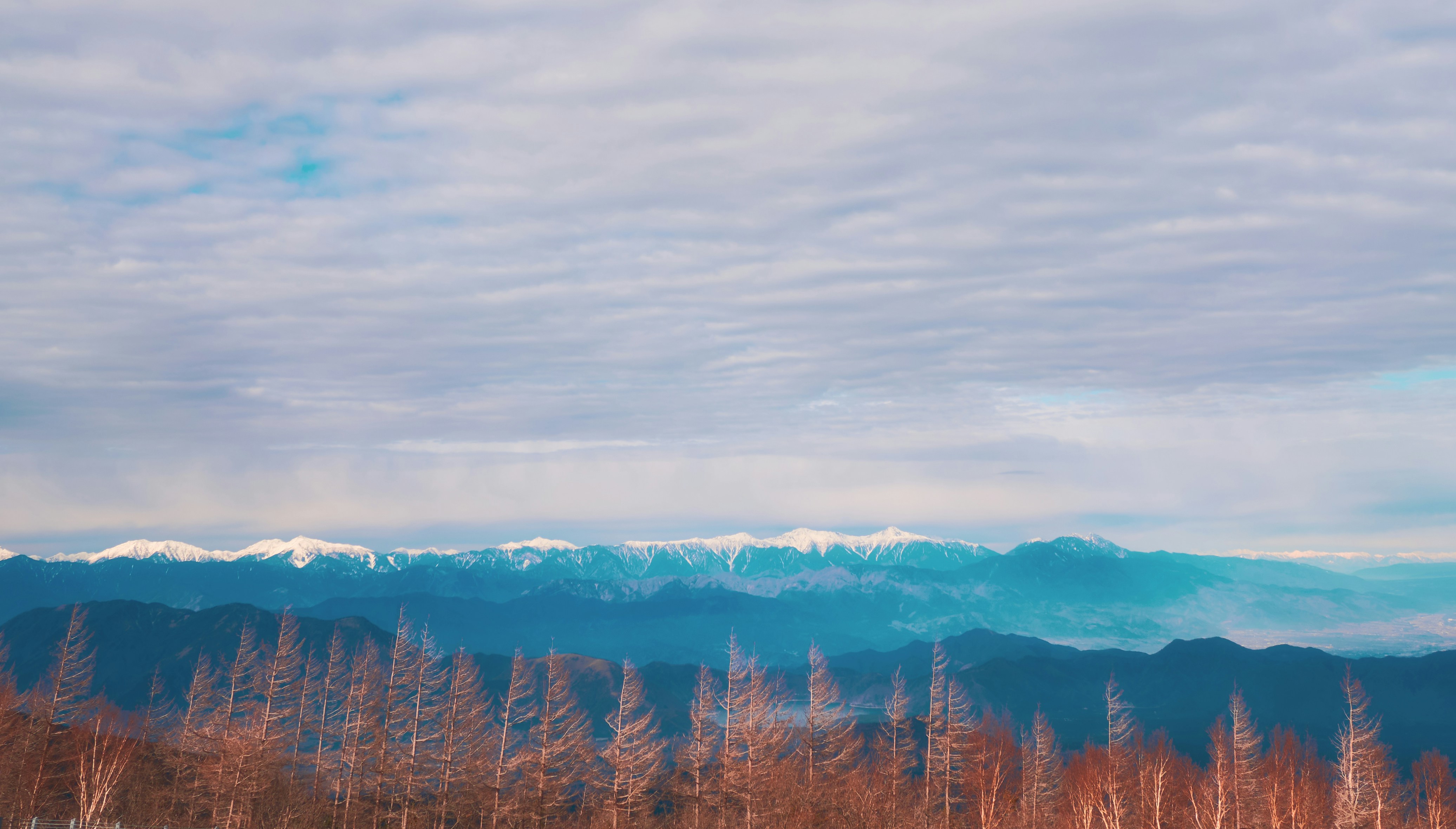 Distant Snowline: A Quiet Ridge Across Winter Haze