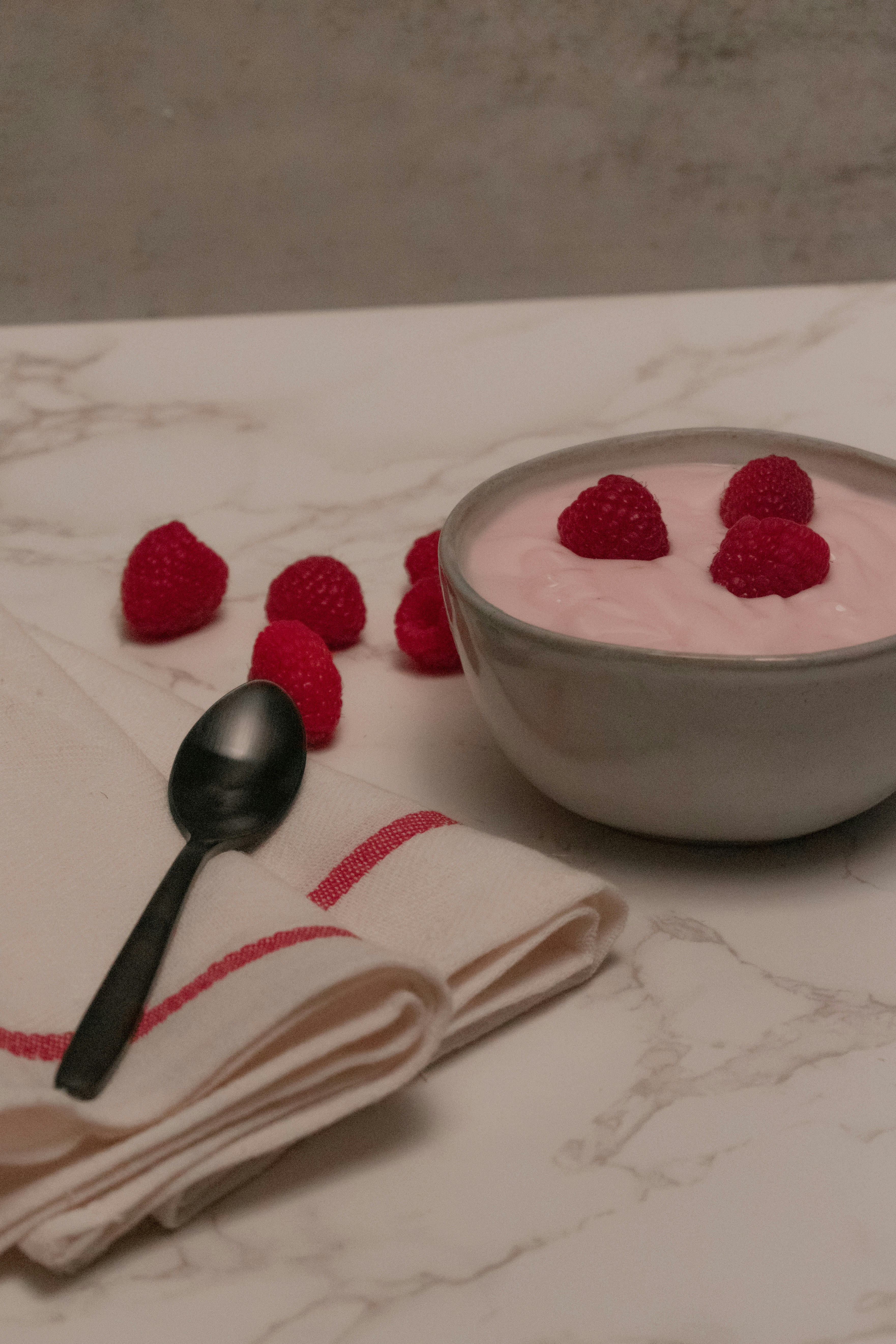 Creamy Raspberry Duo: A Bowl of Soft Yogurt with Fresh Berries on Marble