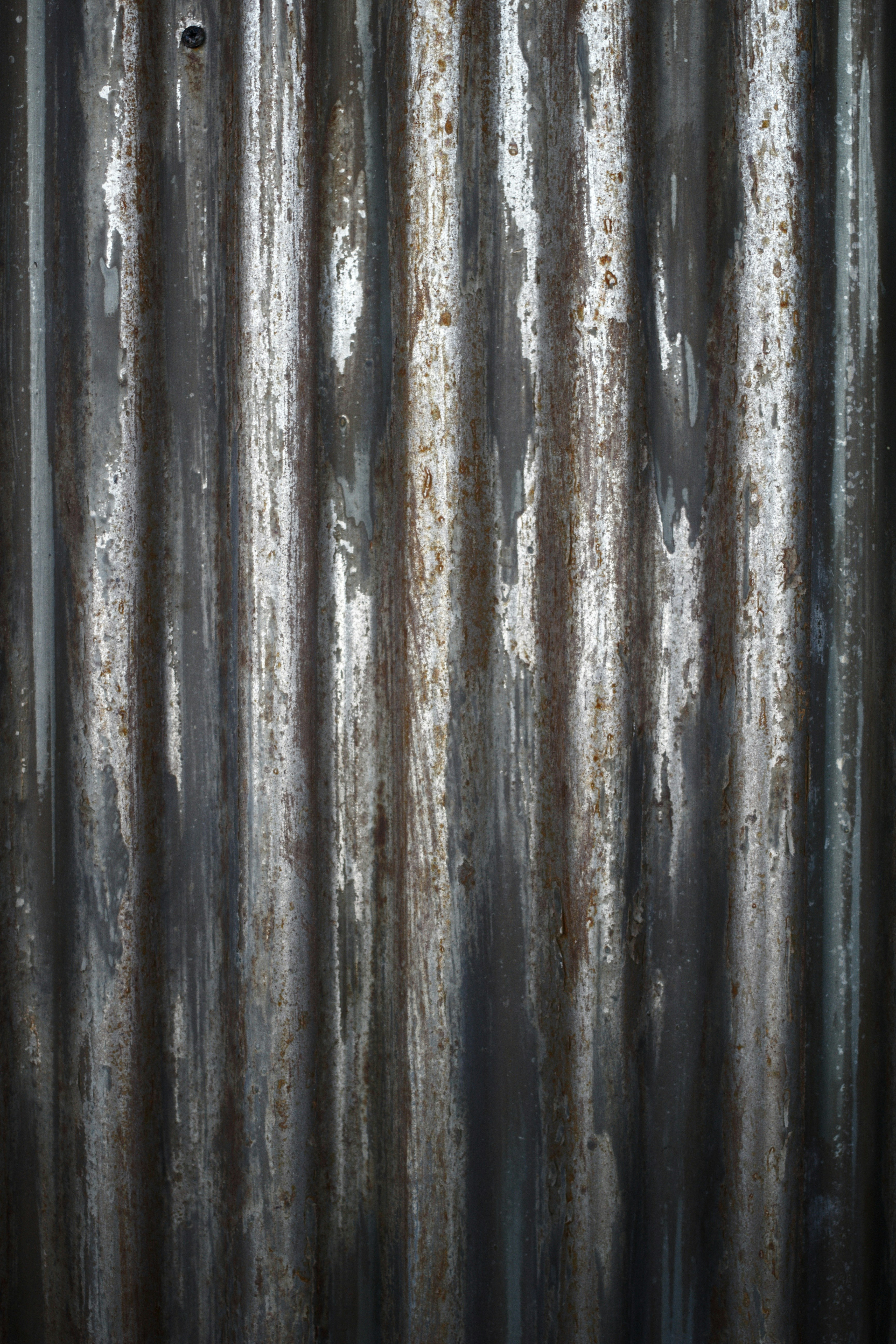Rusted Rivulets: Vertical Texture on a Weathered Metal Wall