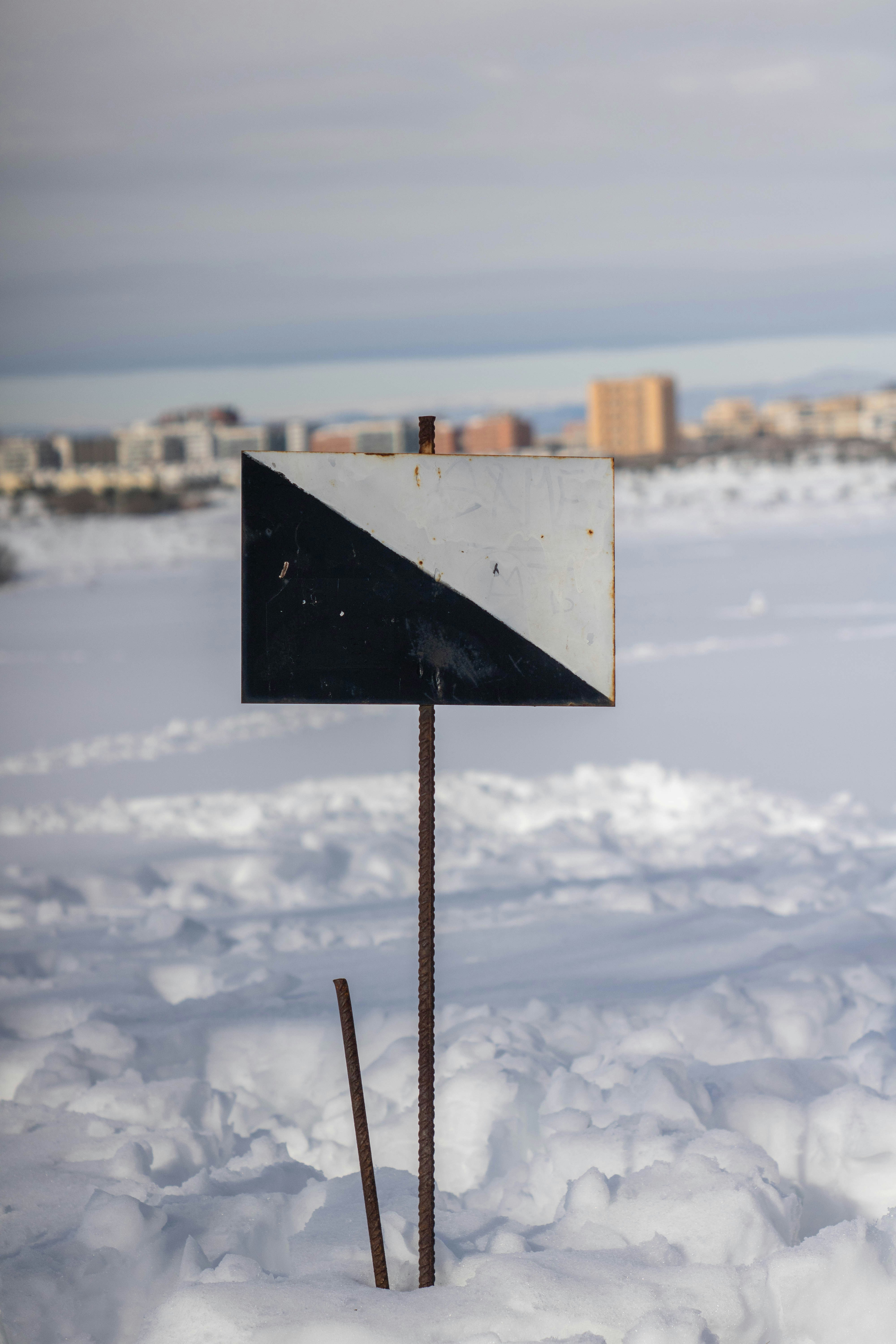 Signpost in a Snowfield: A quiet diagonal of rust and weathered metal