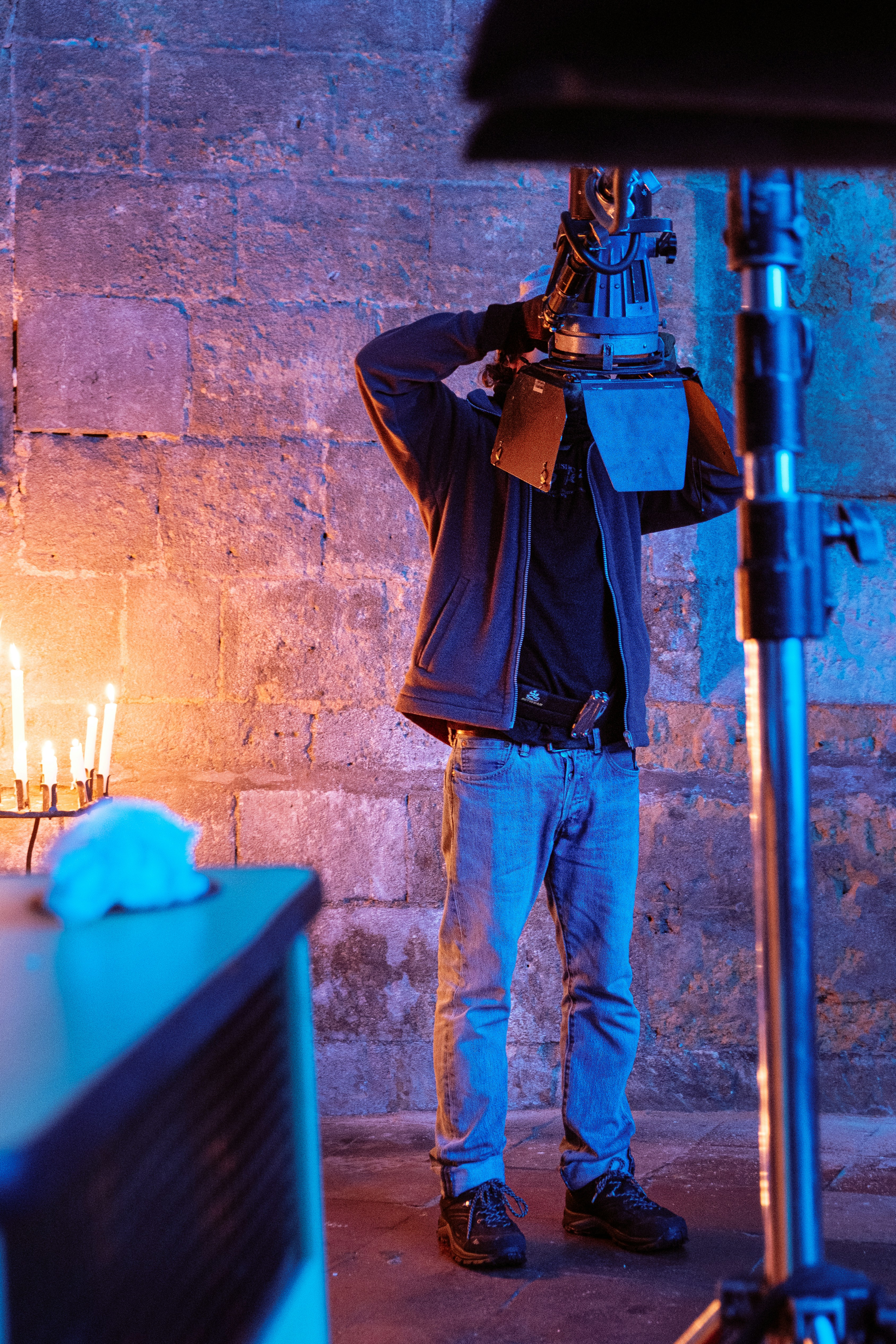 Head-Worn Filmmaking Rig Under Blue and Amber Candlelight in a Stone Studio