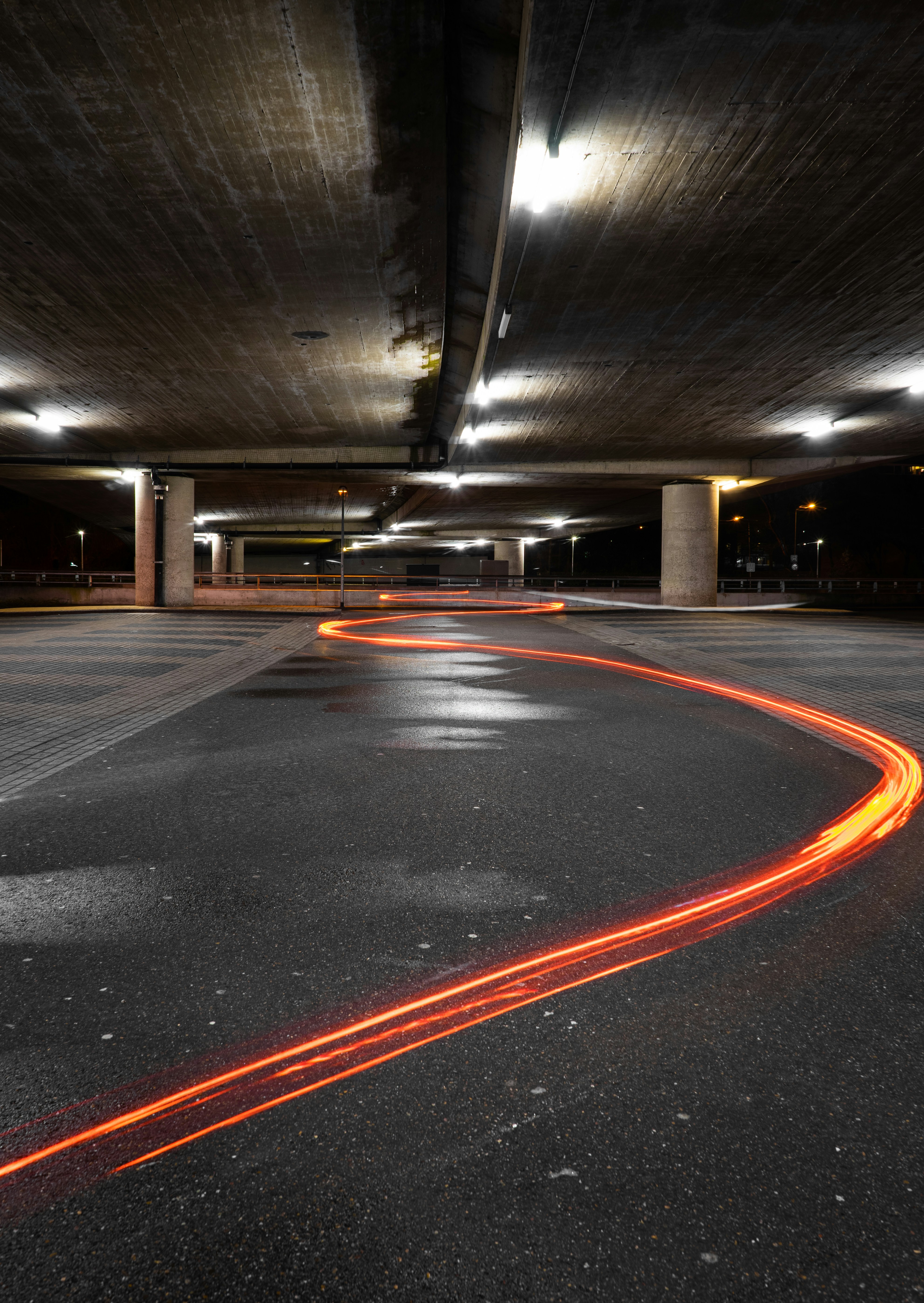 Arc of Ember Through a Quiet Parking Garage