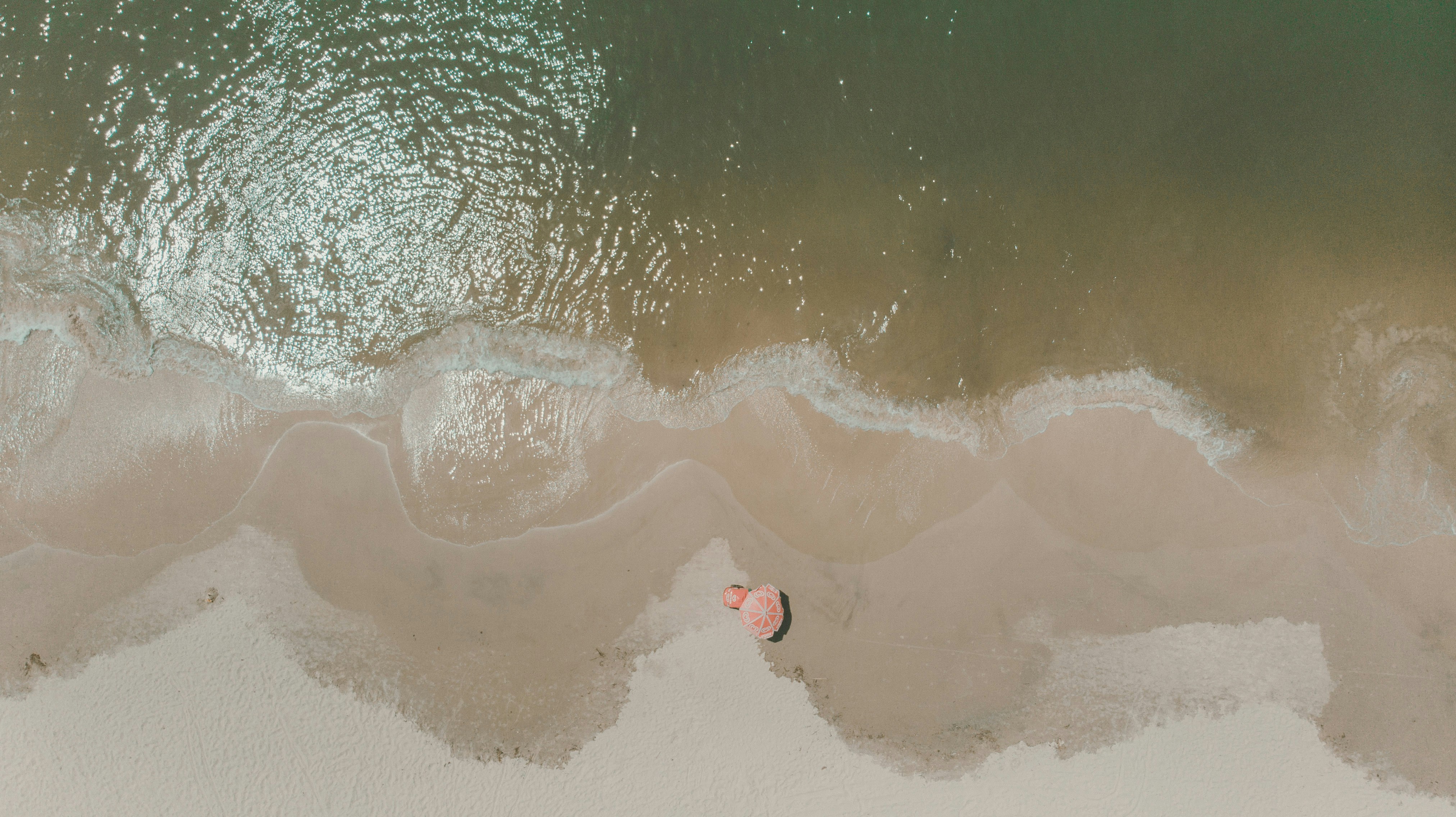 Pink Along the Tidal Edge: A Lone Beachgoer from Above