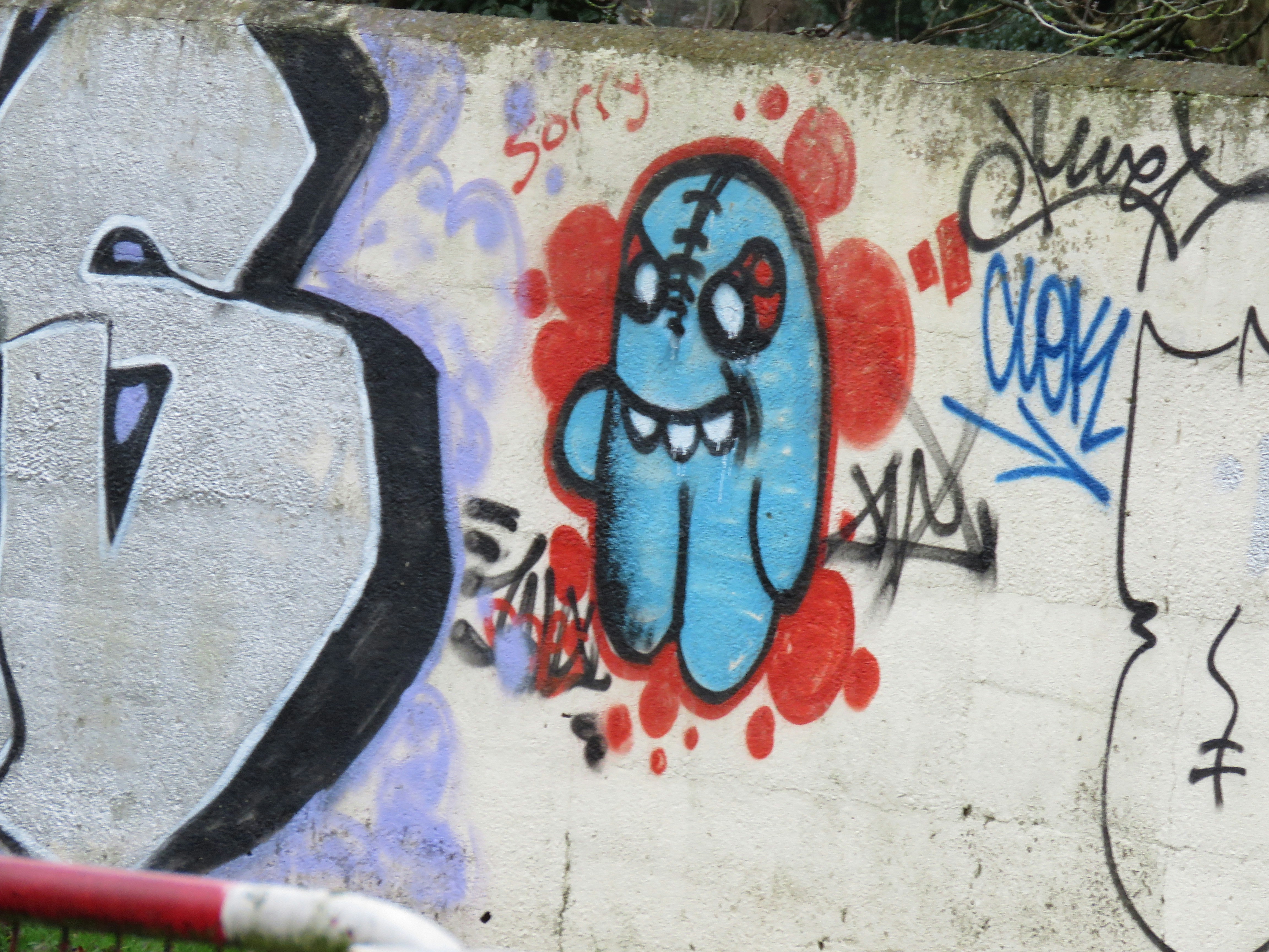Azure Cartoon Surrounded by Crimson Dots on a Graffiti Wall
