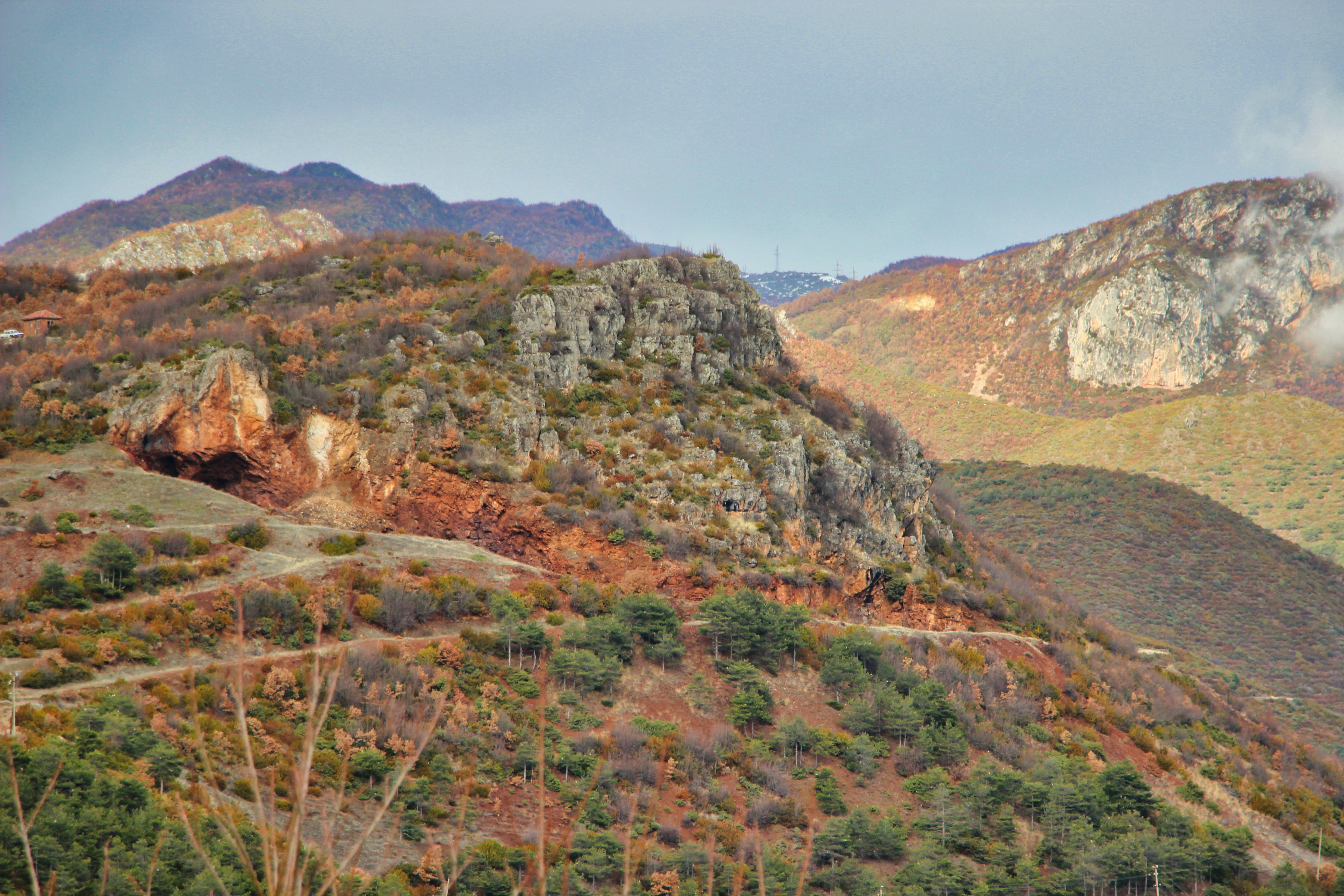 Rugged hillside tapestry: warm autumn tones atop stony outcrops