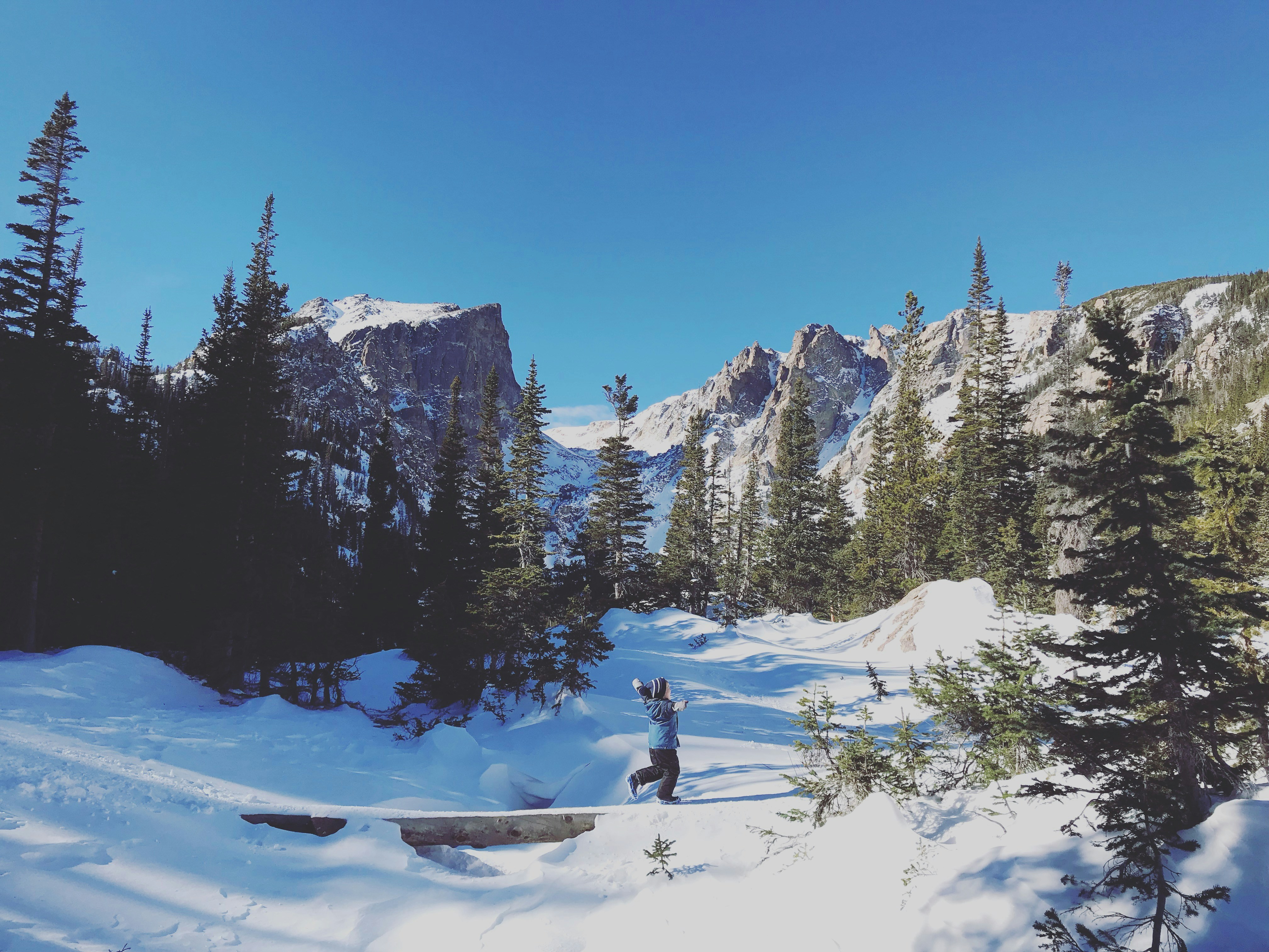 Person riding on snowboard on snow covered mountain during daytime ...