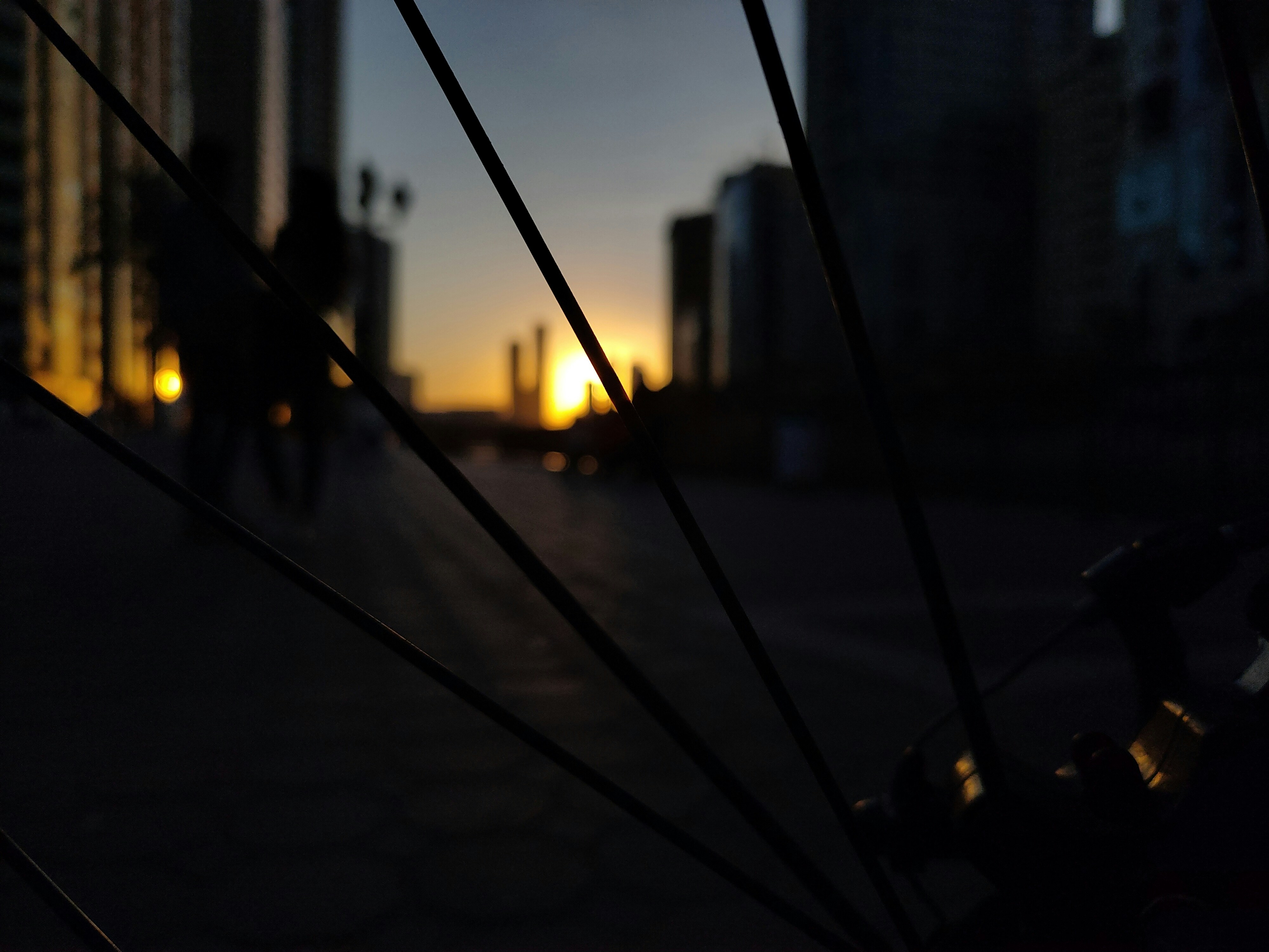 Sunset Glow Between Rails: Urban Silhouette in Shadowed Grid