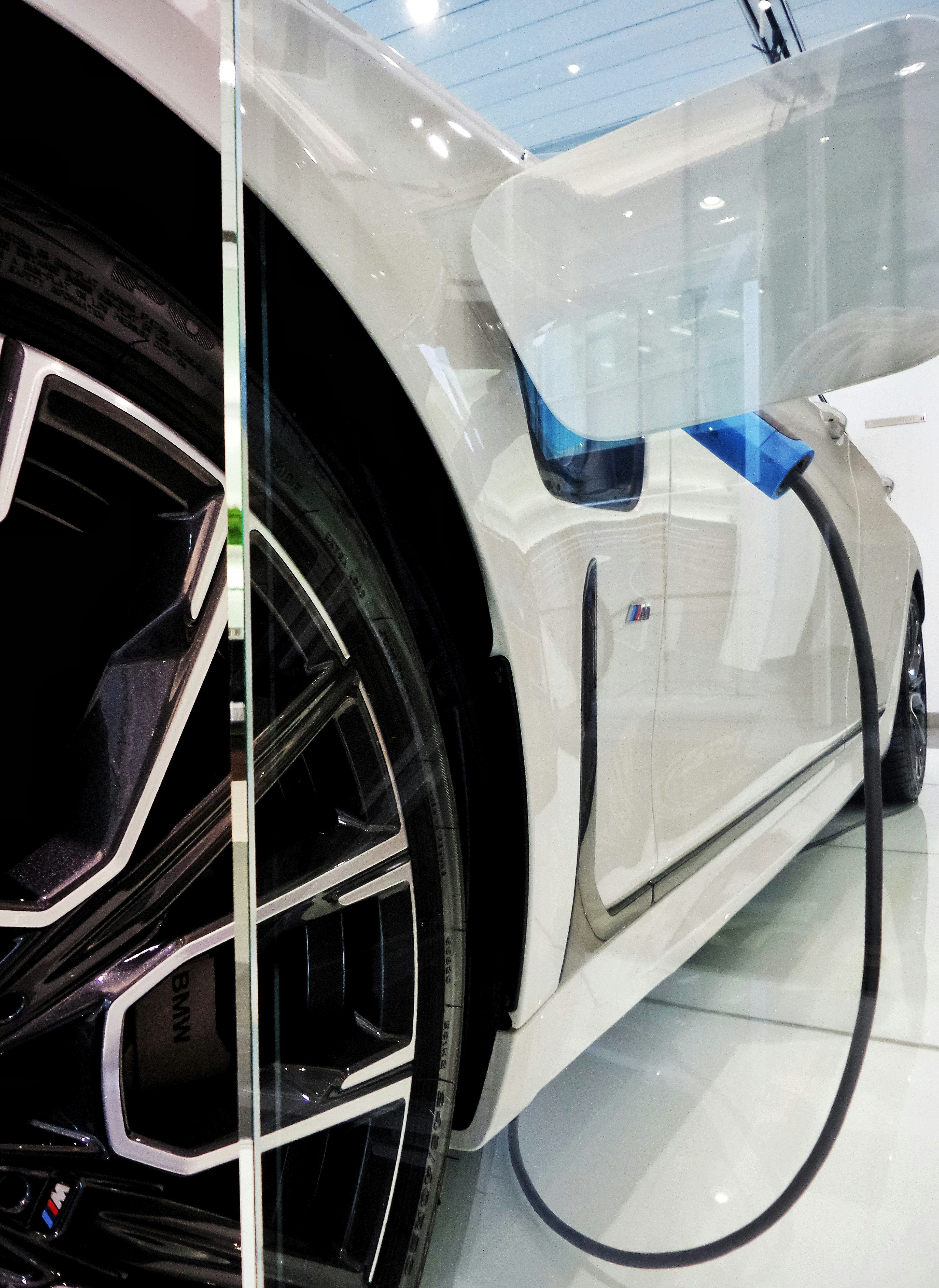 Showroom Charge: Close-up of a white BMW with a charging cable