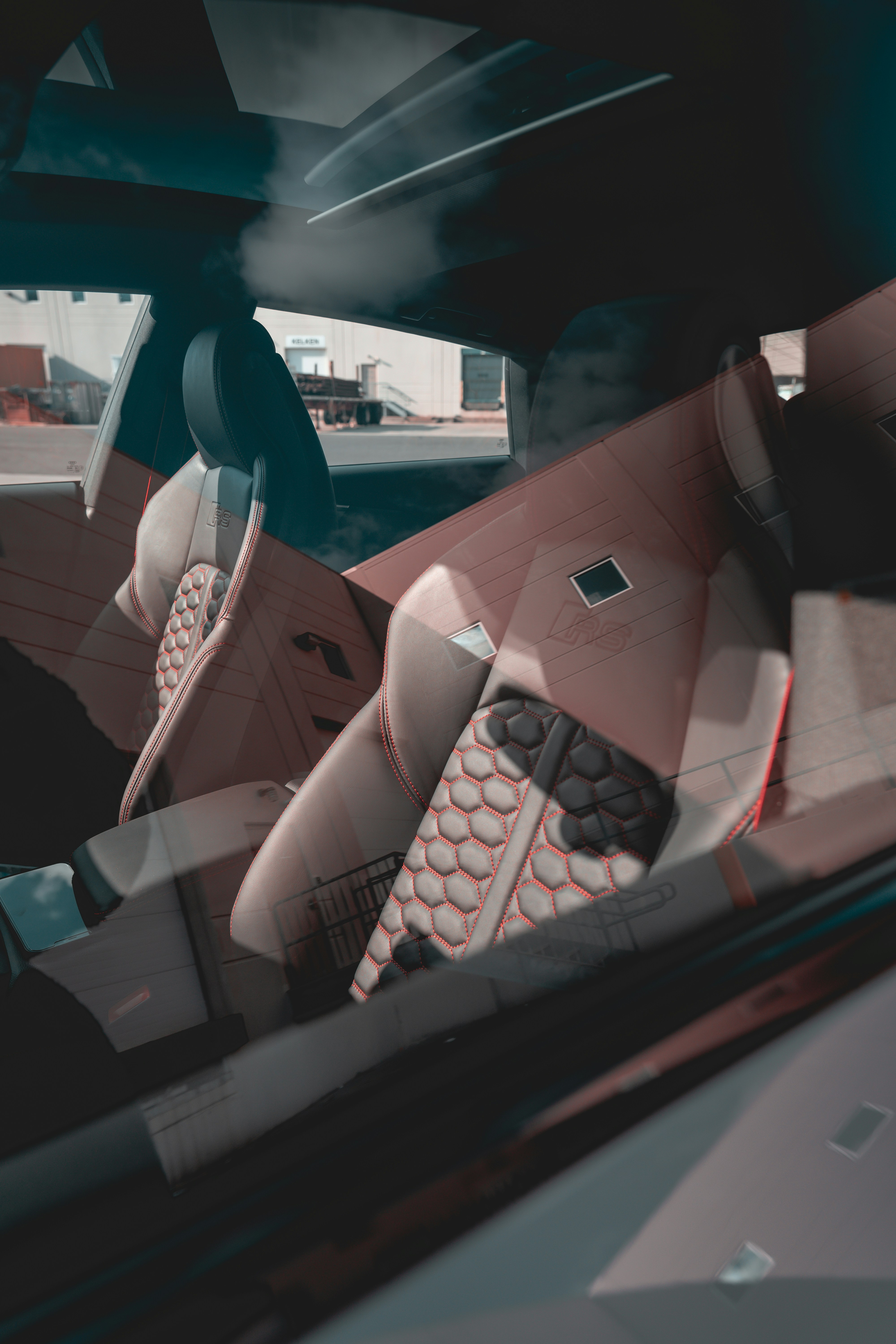 Interior of a luxury car showcasing intricately designed seats with a modern aesthetic and reflective surfaces.