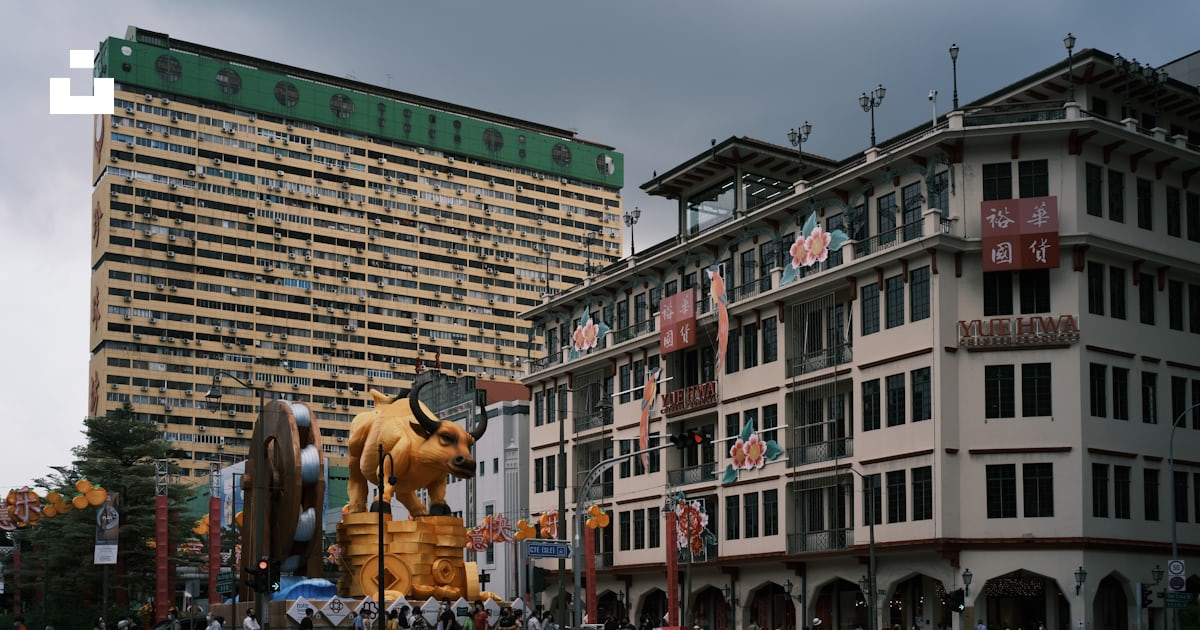 昼間に茶色のコンクリートの建物の近くの通りを歩く人々の写真 Unsplashの無料シンガポール写真
